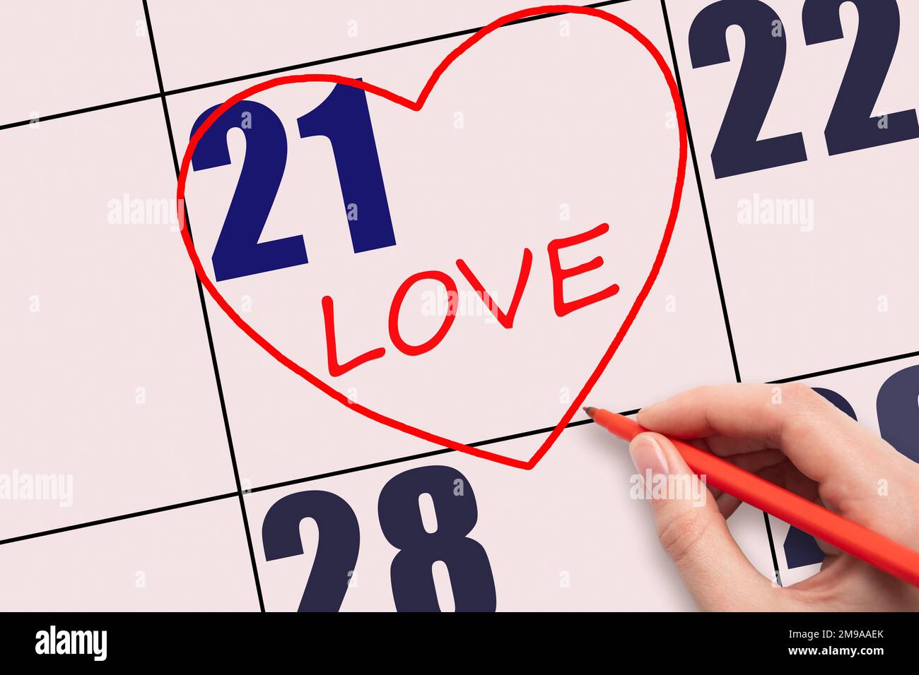 21st day of the month. Hand writing text LOVE and drawing a red heart ...