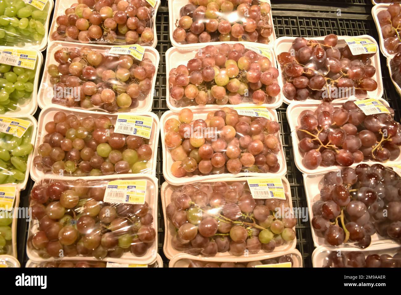 A Closeup view of bunch of Grapes packed with plastic paper in a ...