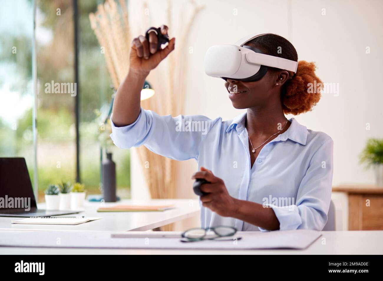 Woman Working From Home Office With Controllers Wearing VR Headset Interacting With AR ...