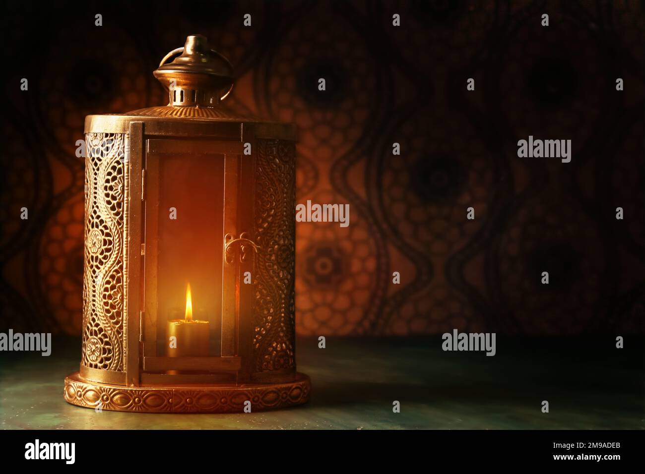 Muslim lantern with glowing candle on dark background with space for ...