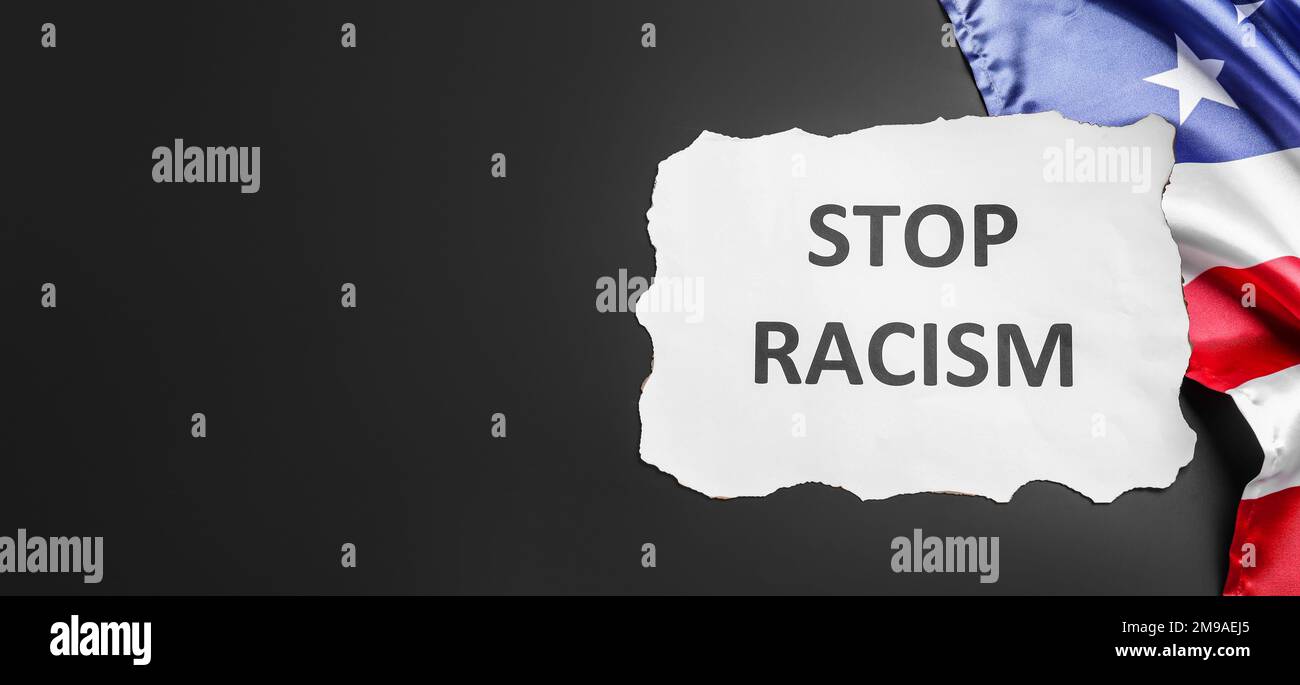 Paper with text STOP RACISM and national flag of USA on dark background ...
