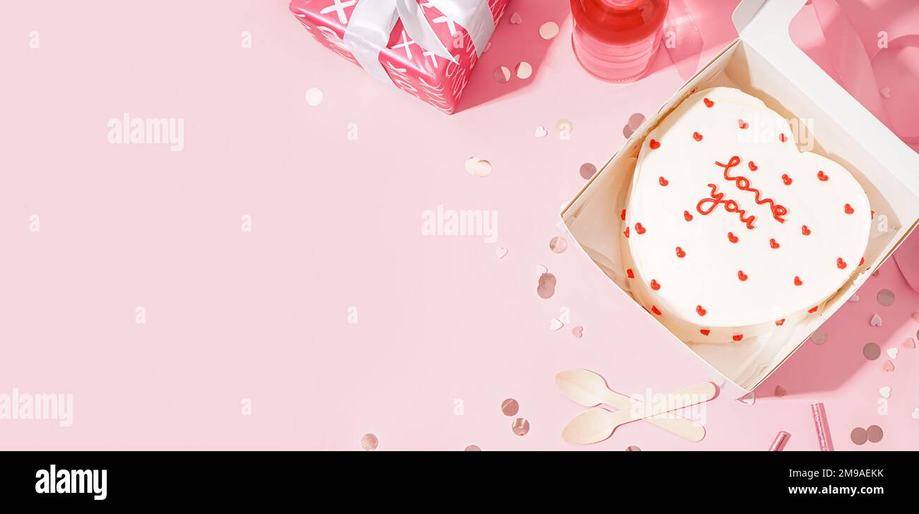 Box with heart-shaped bento cake on pink background with space for text ...