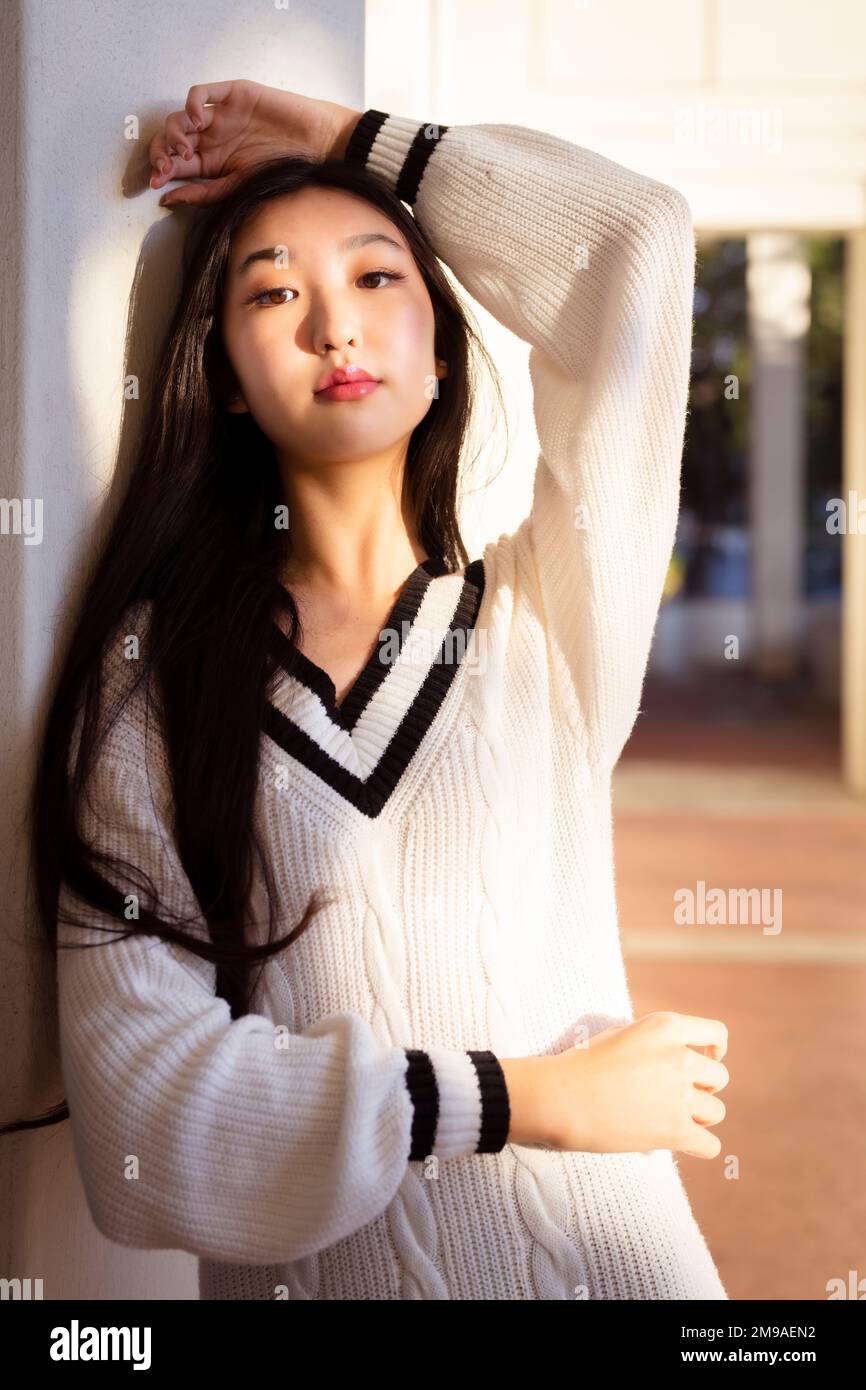 Teenage Girl in White and Black Sweater Dress Leaning Against a Wall at ...