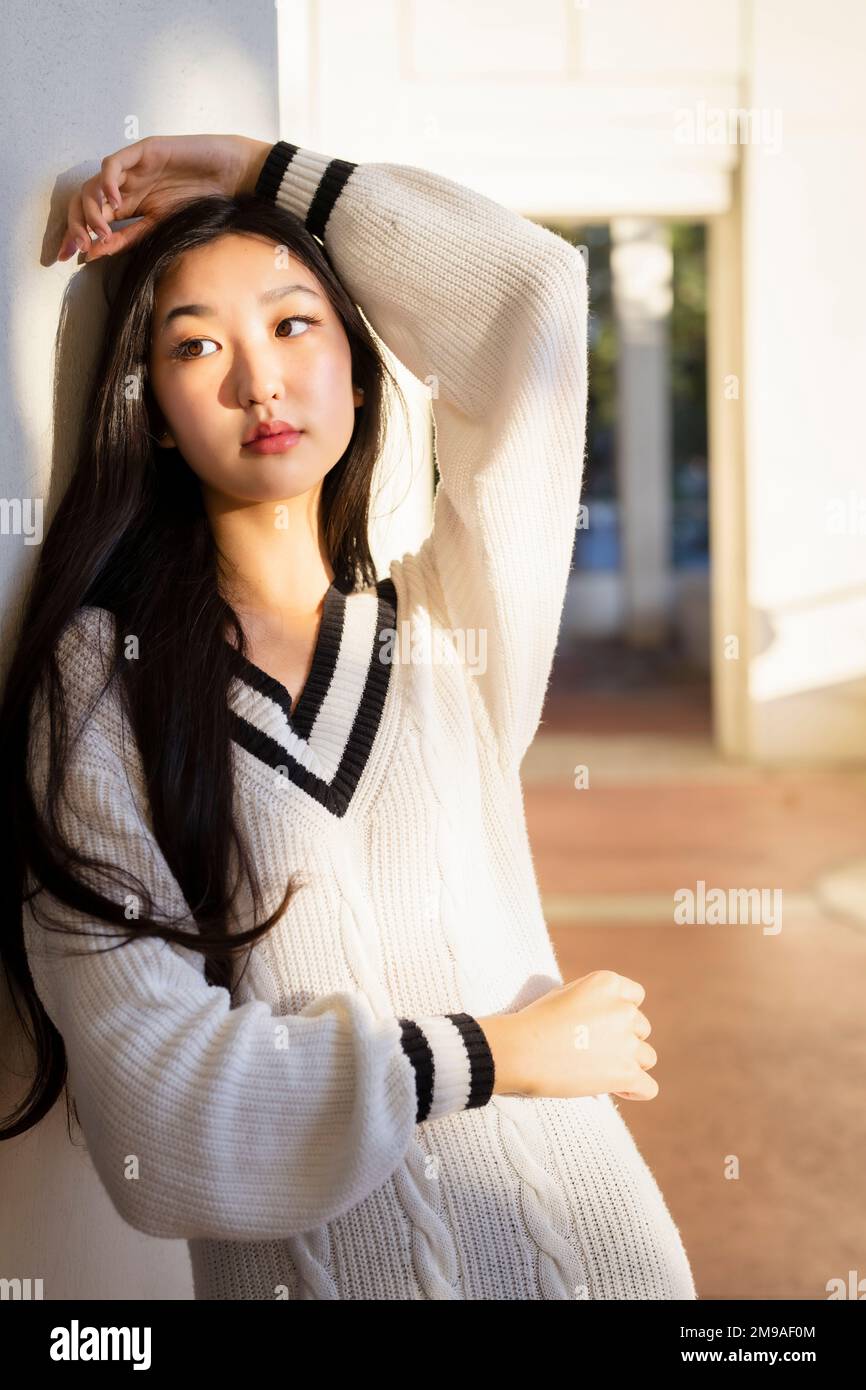 Teenage Girl in White and Black Sweater Dress Leaning Against a Wall at ...