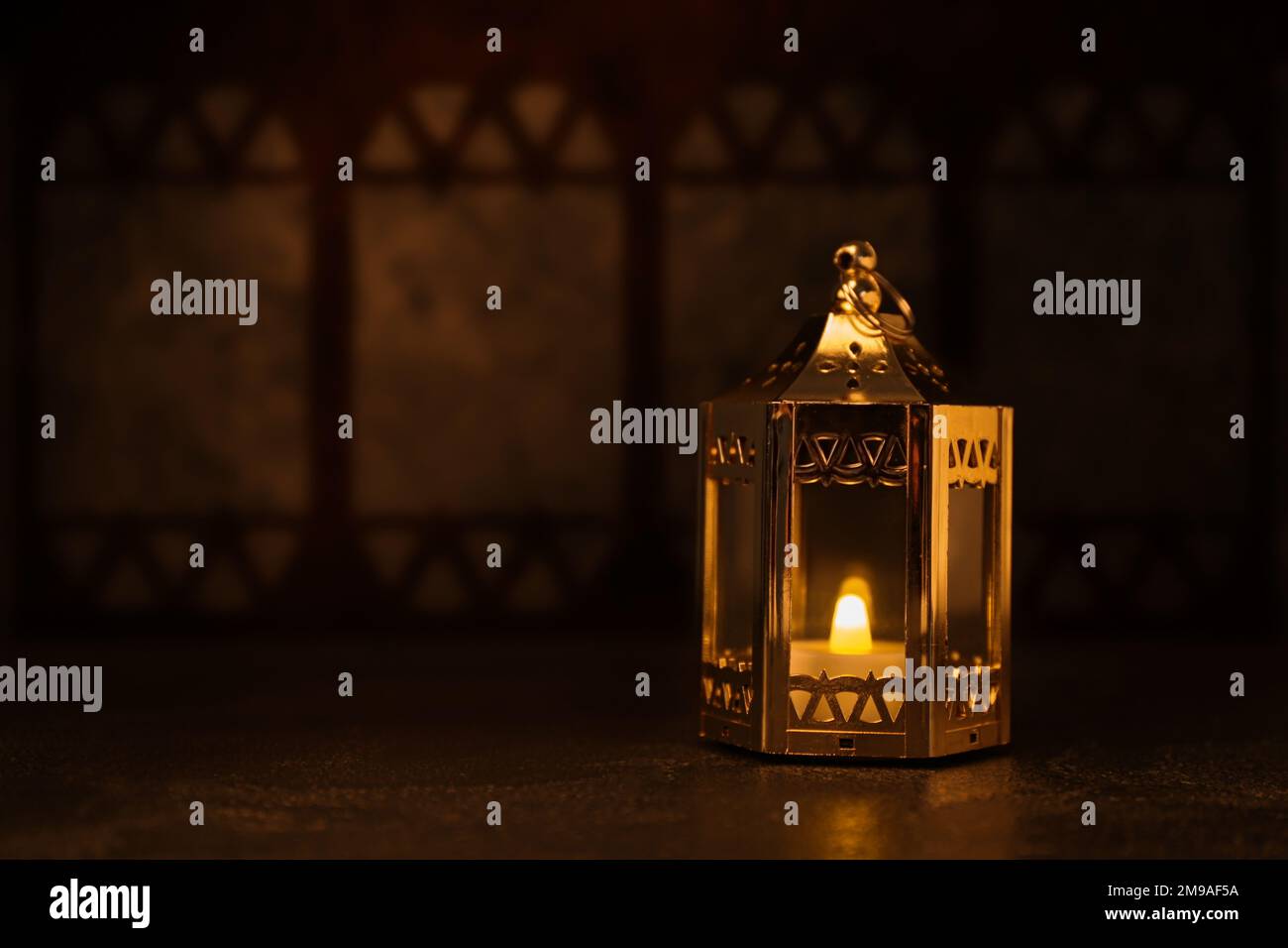 Muslim lantern with glowing candle for Ramadan on dark background with ...