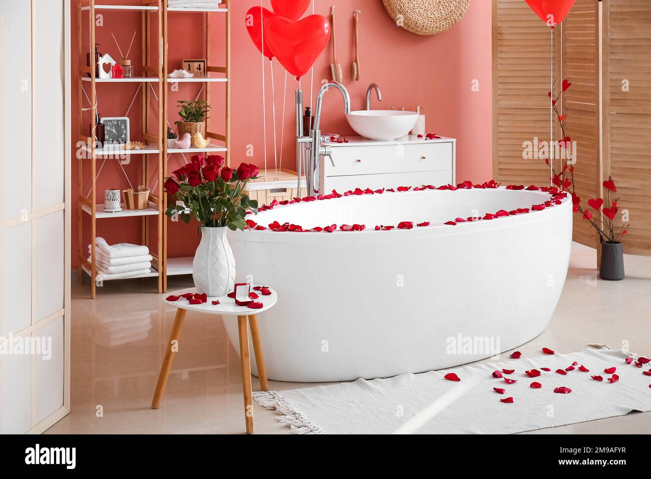 Interior of bathroom decorated for Valentine's Day with bathtub, roses ...