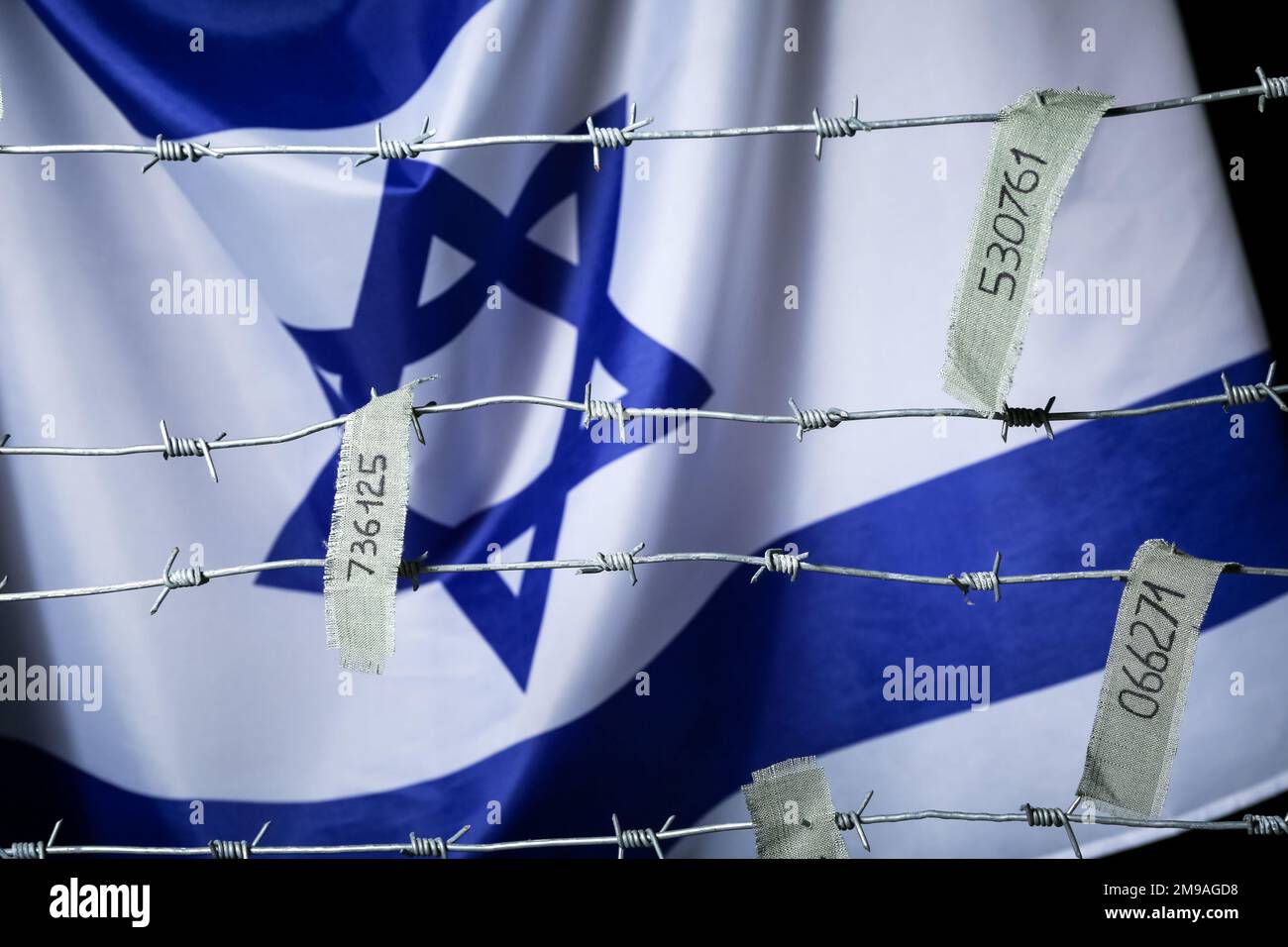 Barbed wire with prisoner numbers against flag of Israel. International ...