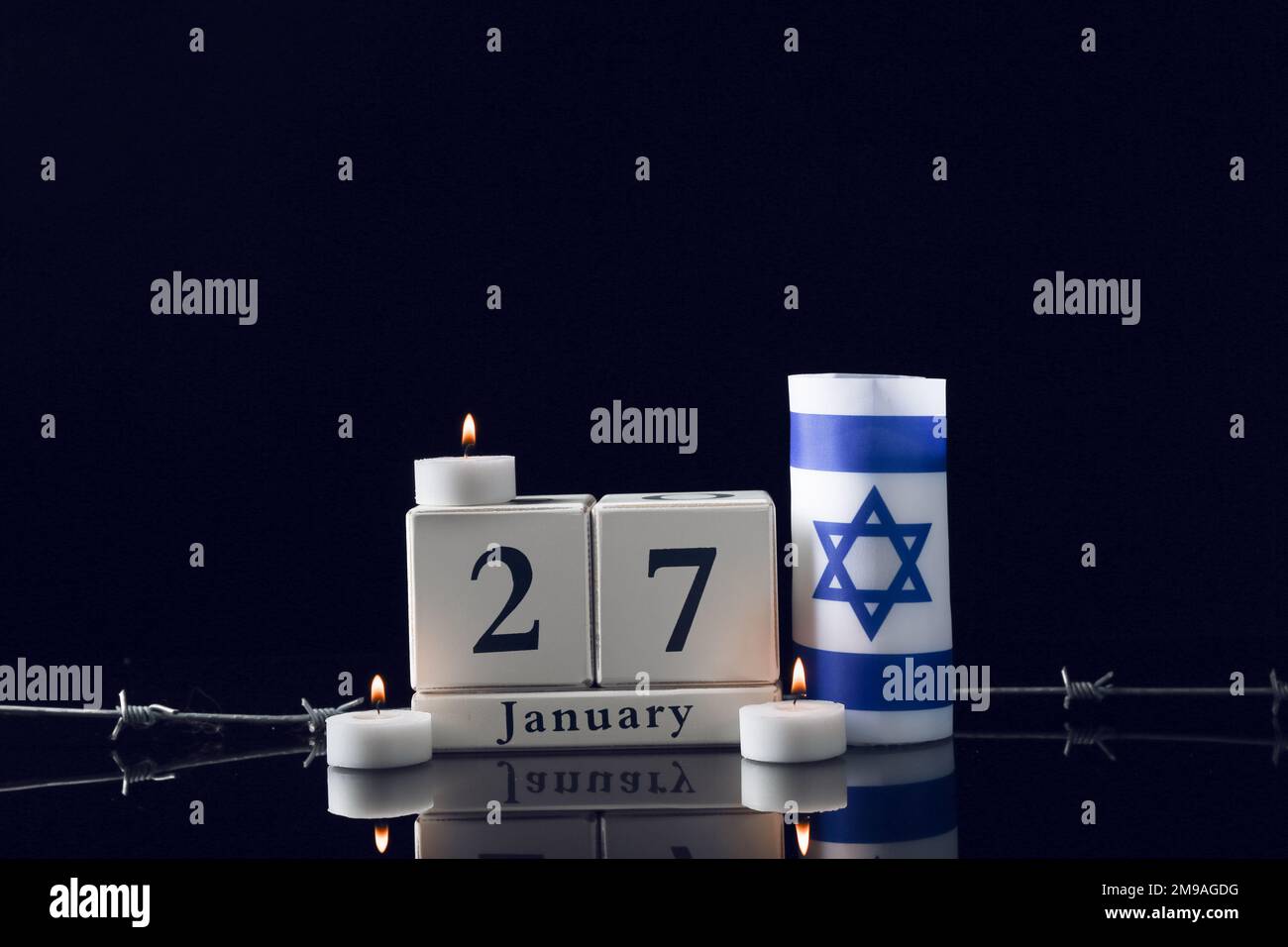 Calendar with date 27 JANUARY, burning candles, barbed wire and flag of ...