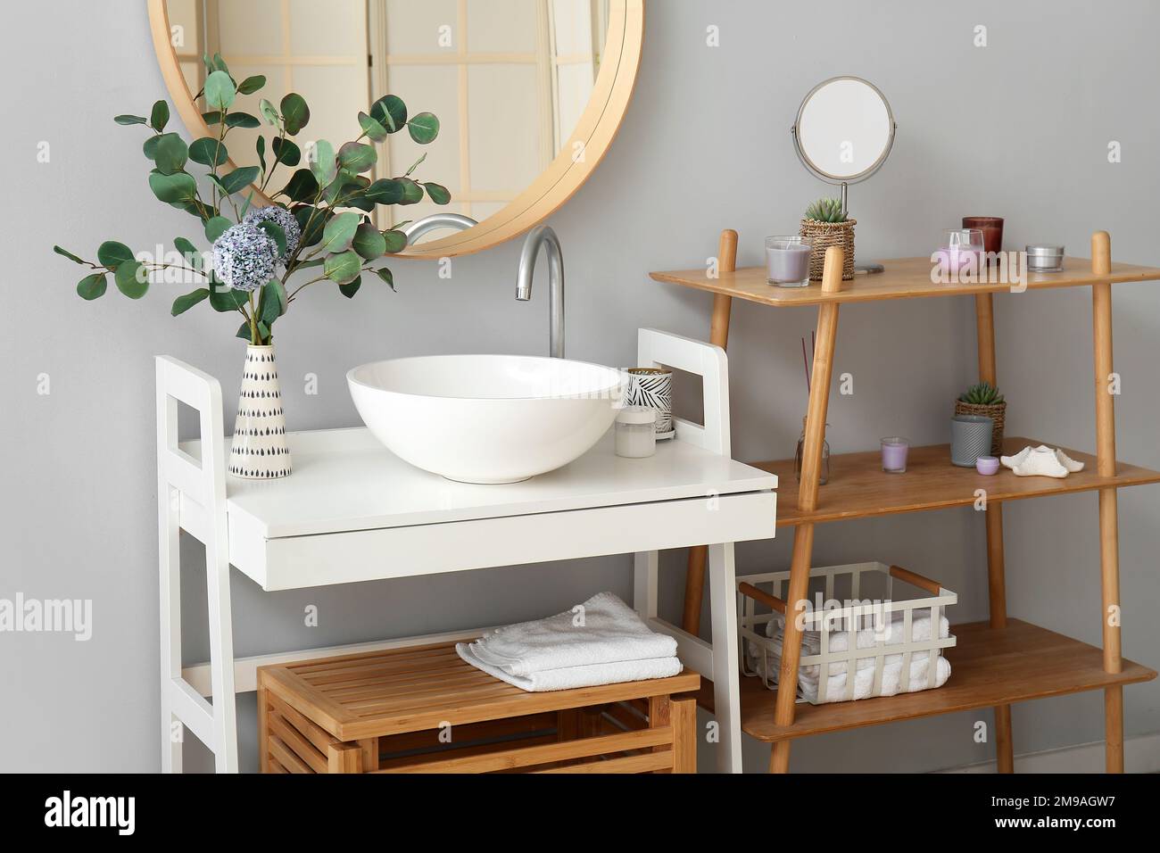 Sink, vase with flowers and eucalyptus on table in bathroom Stock Photo ...