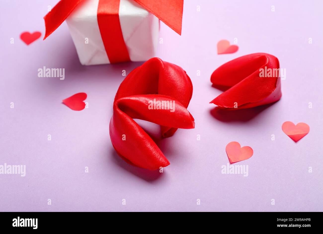 Red fortune cookies and paper hearts on lilac background. Valentine's ...