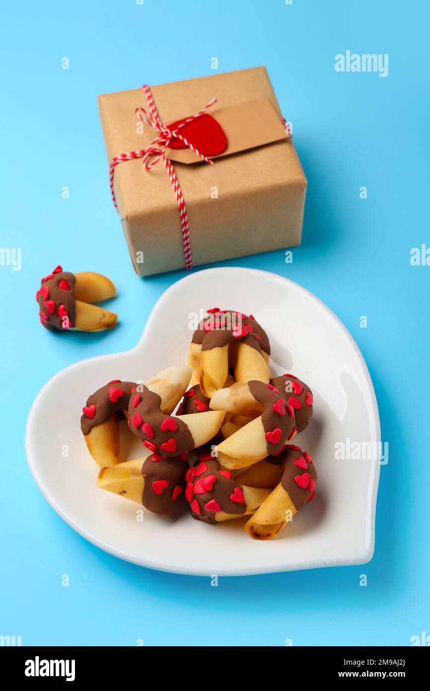 Plate of fortune cookies with gift on blue background. Valentine's Day ...