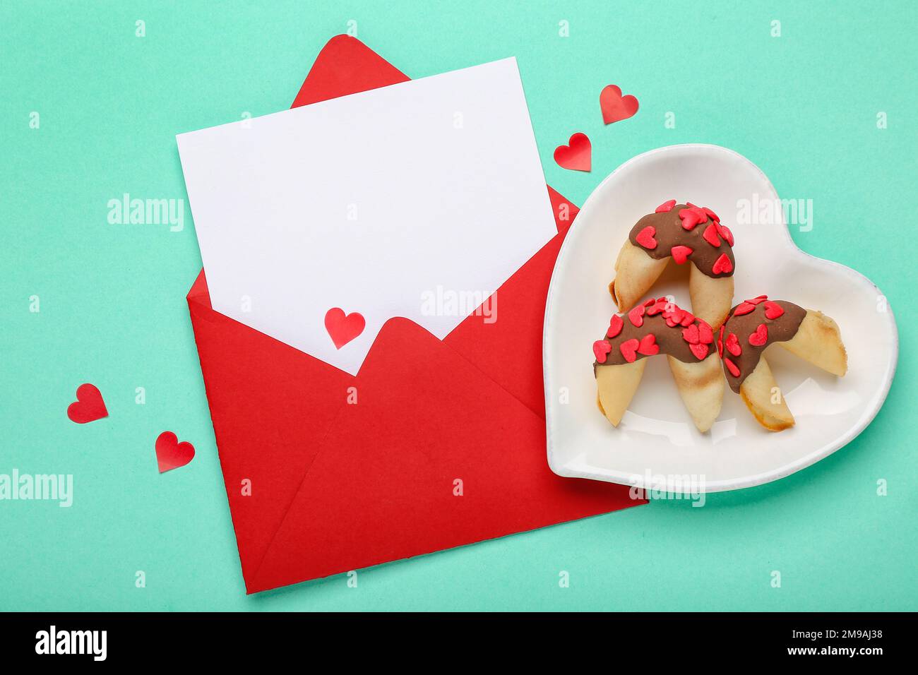Plate of fortune cookies and envelope on green background. Valentine's ...
