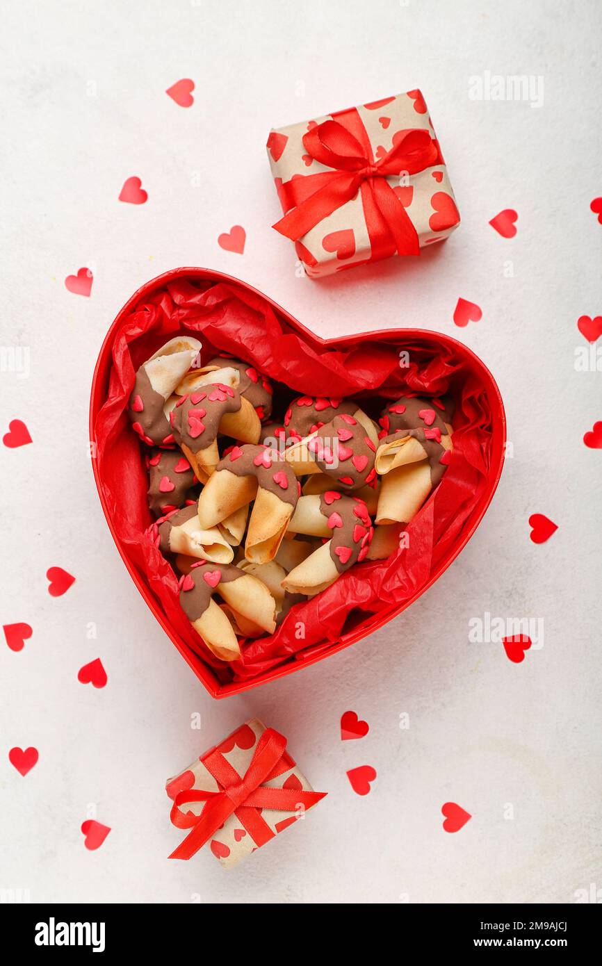 Box with fortune cookies, gifts and hearts on white background ...