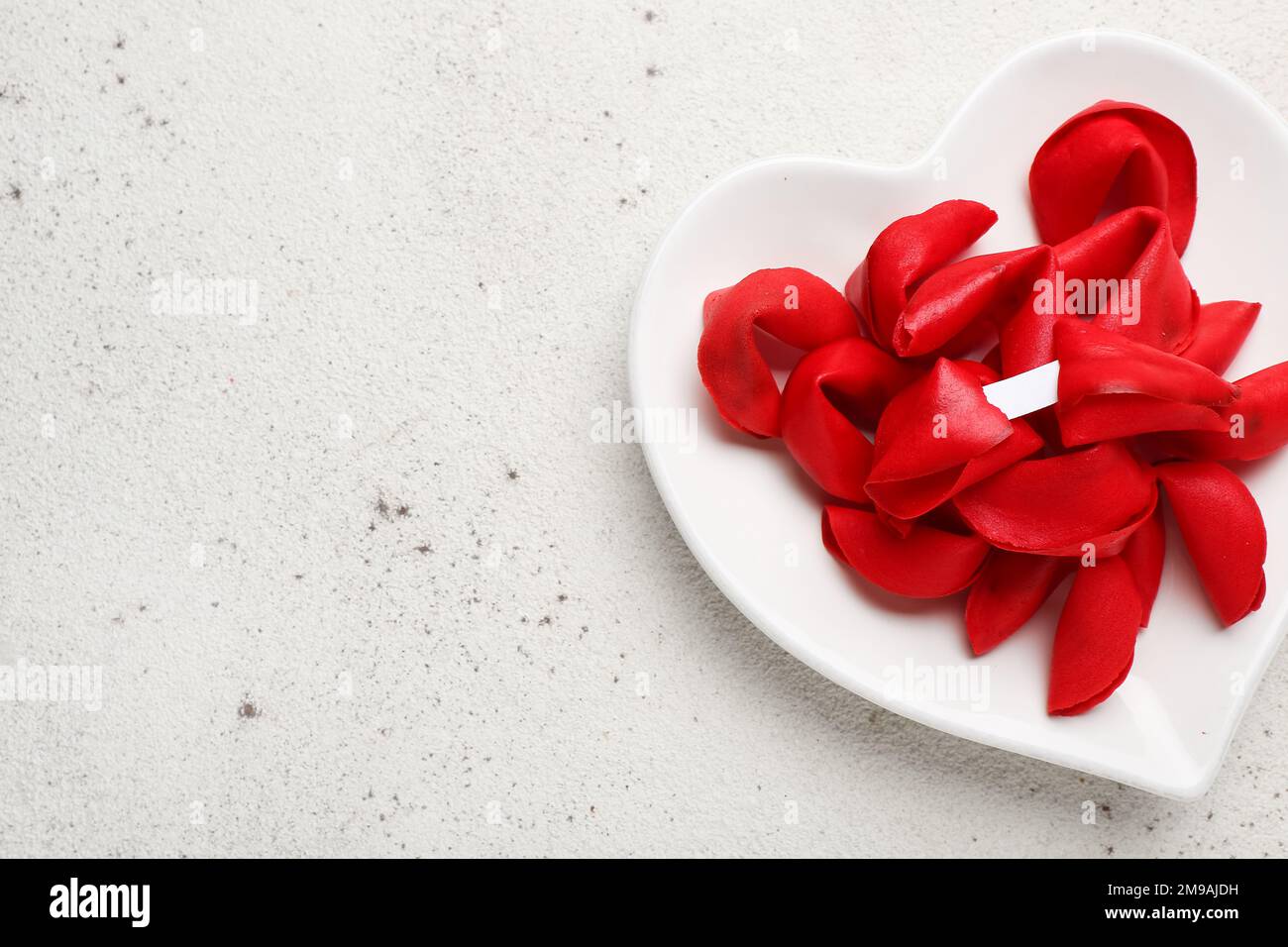 Plate with red fortune cookies on light background. Valentine's Day ...
