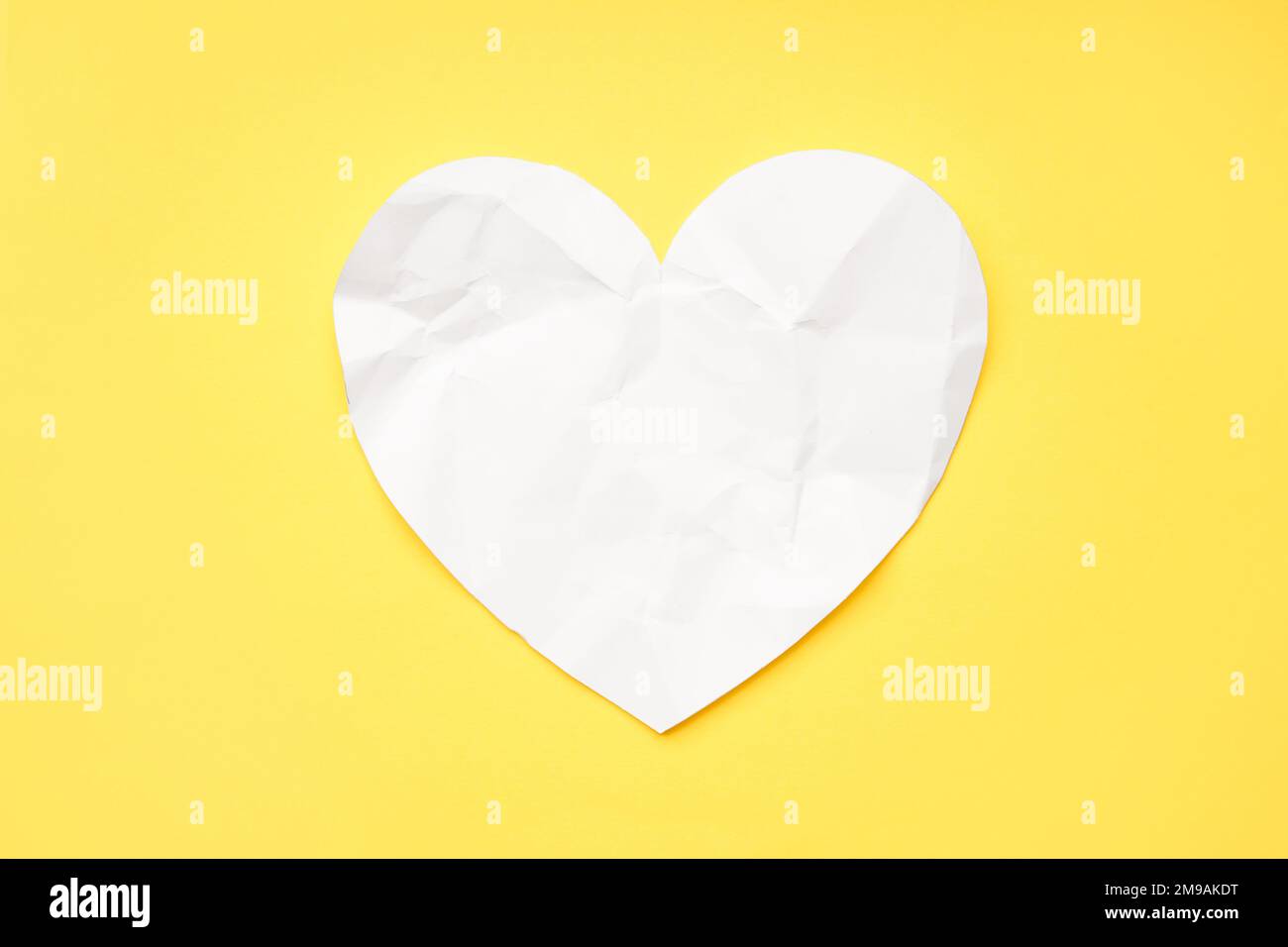 Crumpled paper heart on yellow background. Valentines Day celebration ...