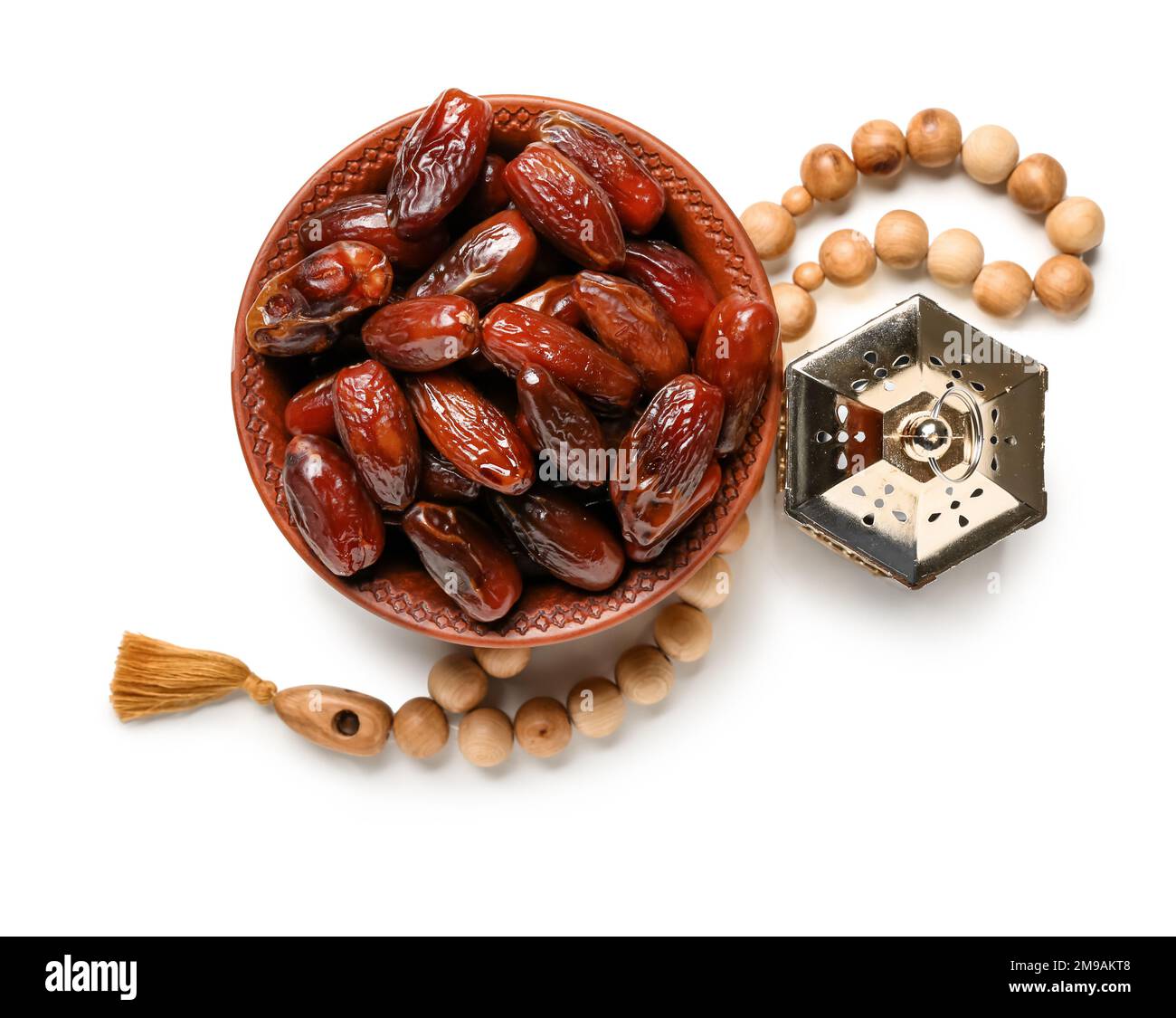 Bowl of dates, prayer beads and Muslim lantern for Ramadan on white ...