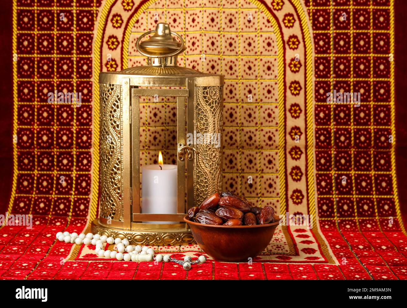 Bowl with dates, prayer beads and Muslim lantern for Ramadan on mat ...