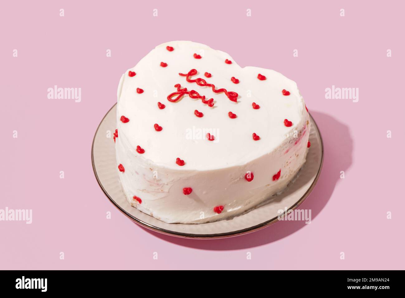 Plate with heart-shaped bento cake on pink background. Valentine's Day ...