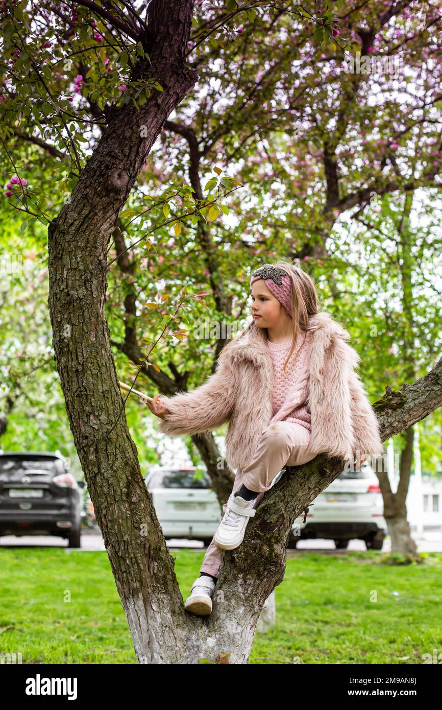 child playing in the garden climbing on the tree Stock Photo - Alamy