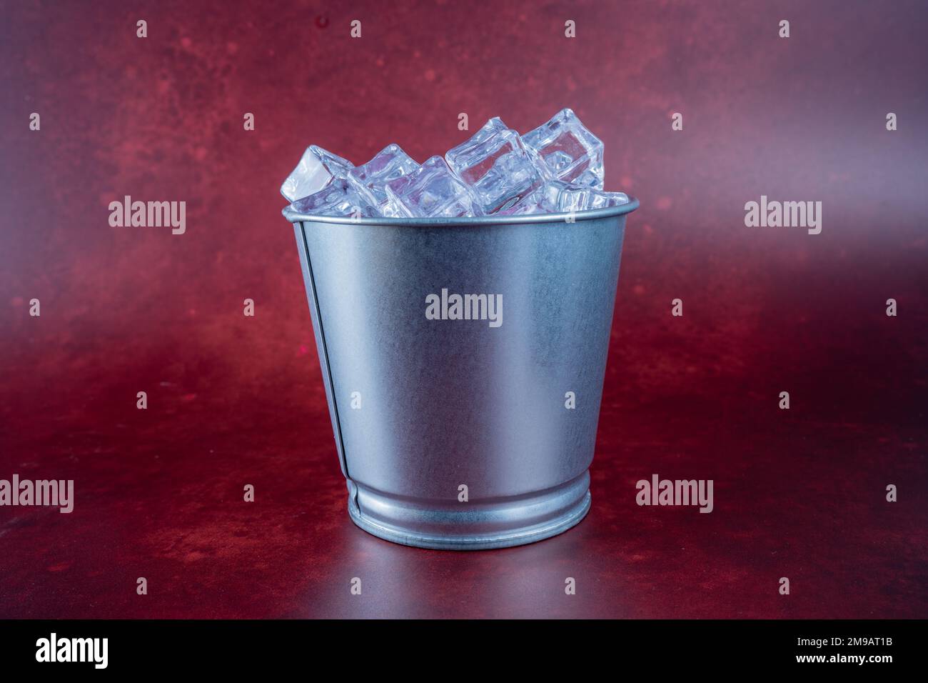 selected focus on Galvanised ice bucket with cubes of ice out of focus ...