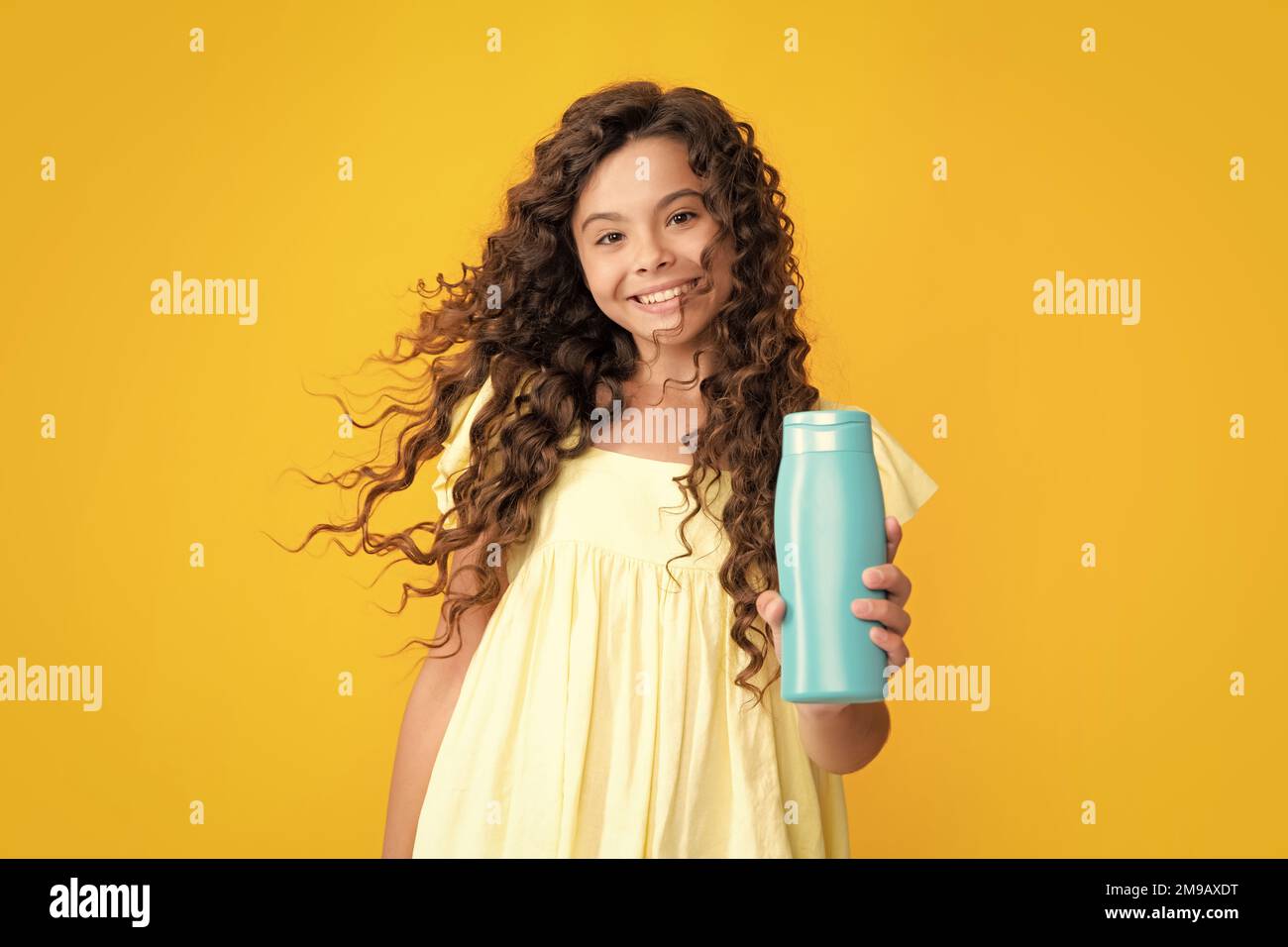 Happy portrait of child teen girl with shampoos conditioners and shower ...