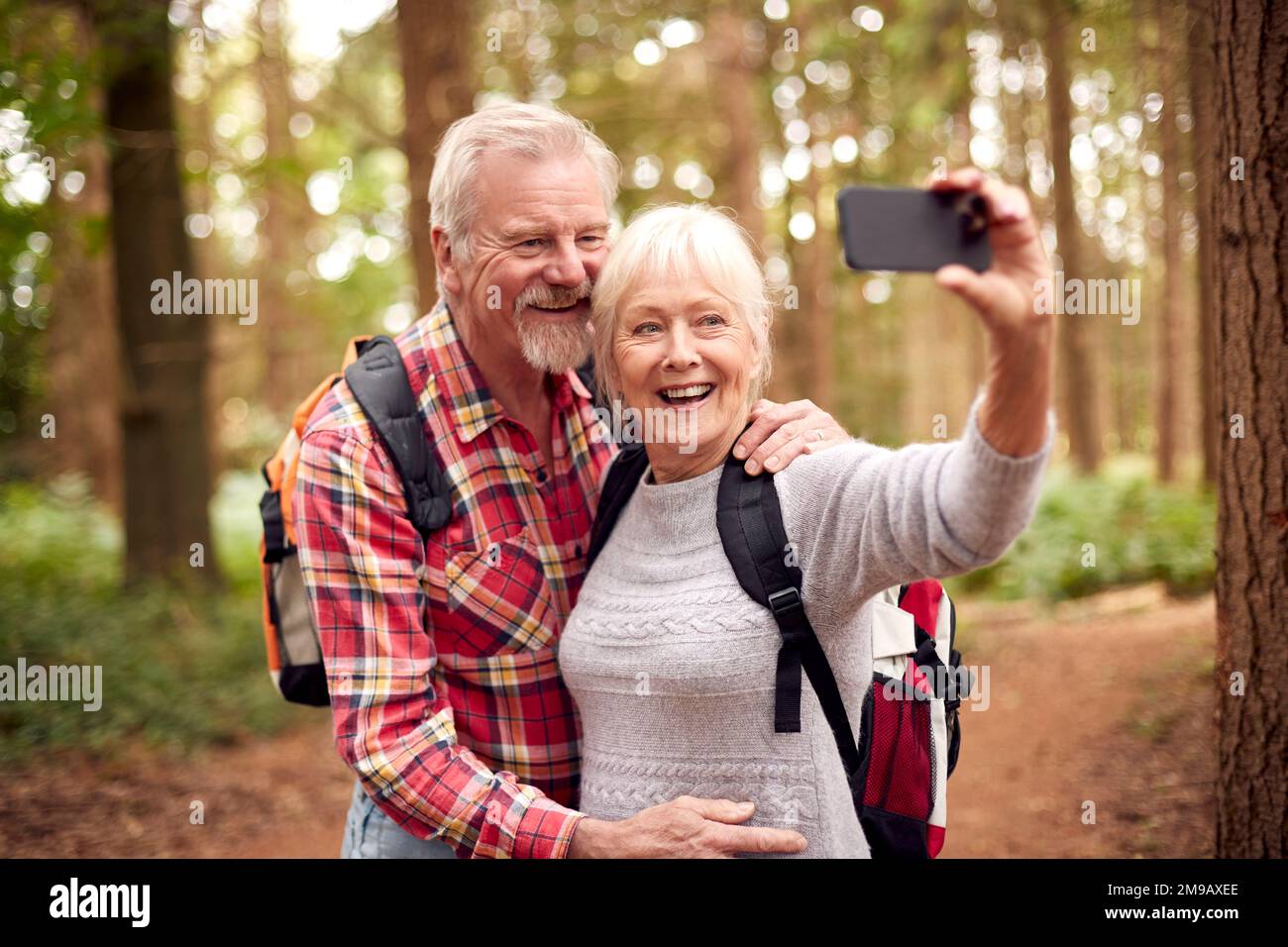 Retired Senior Couple Posing For Selfie On Mobile Phone Hiking In ...