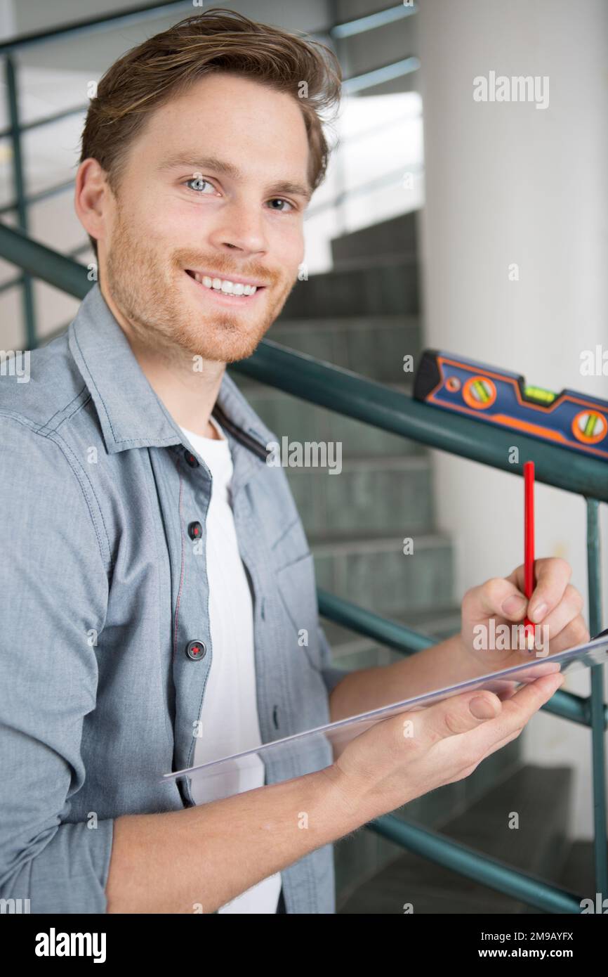 maintenance man working with level measurement tool fixing the stairs ...
