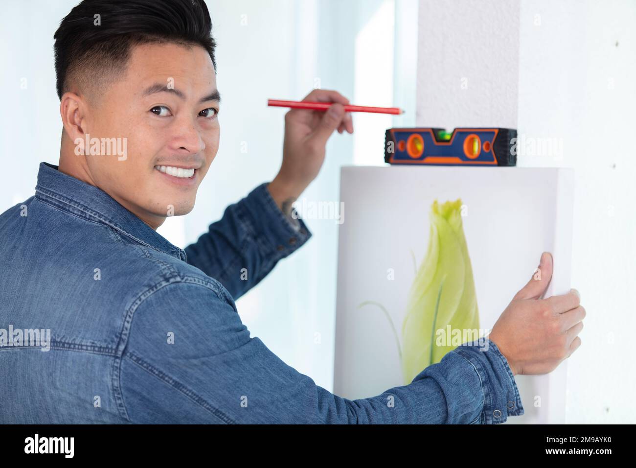 mature man using a spirit level and marking the wall Stock Photo - Alamy