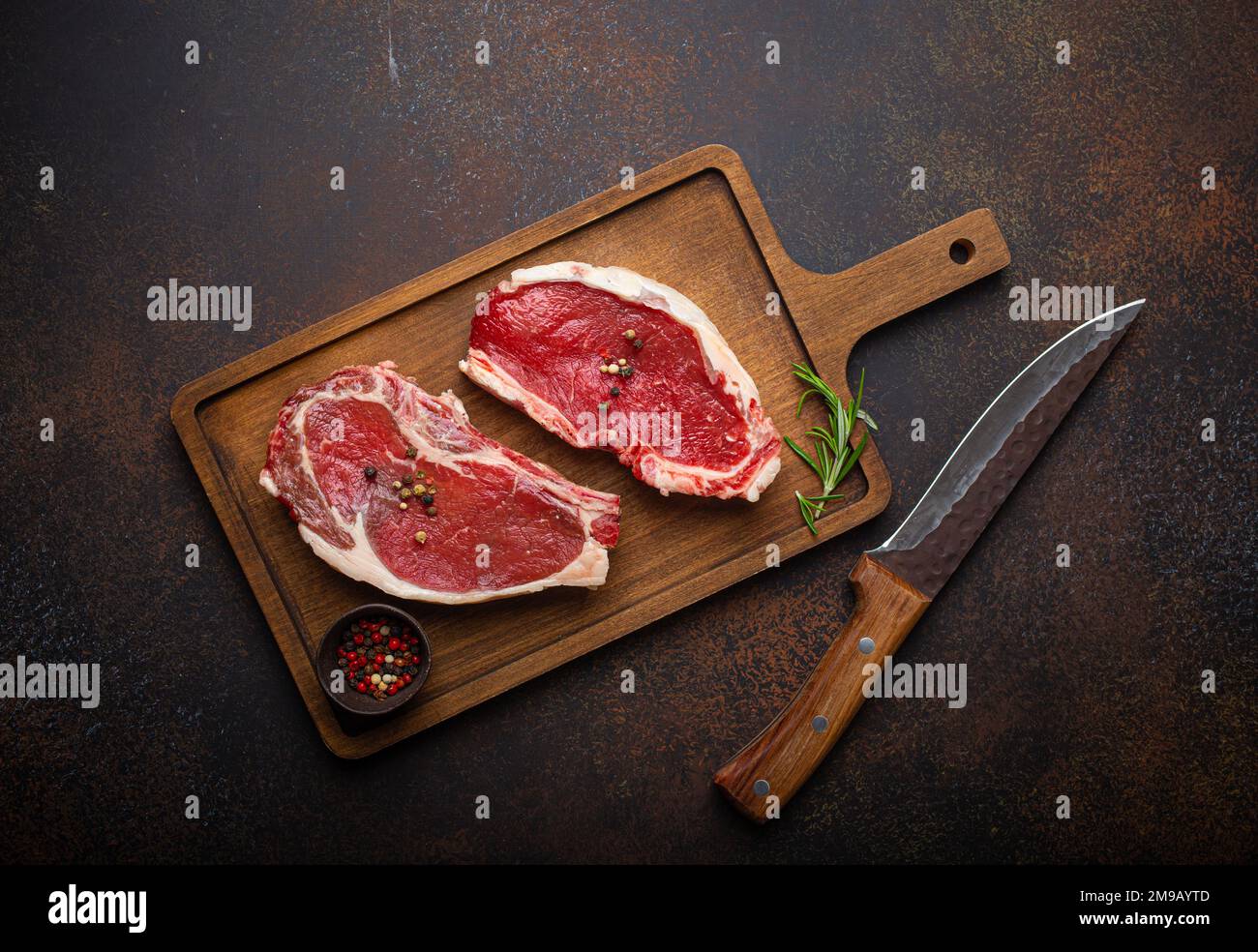 Two raw meat beef rib eye marbled steaks on wooden cutting board Stock ...
