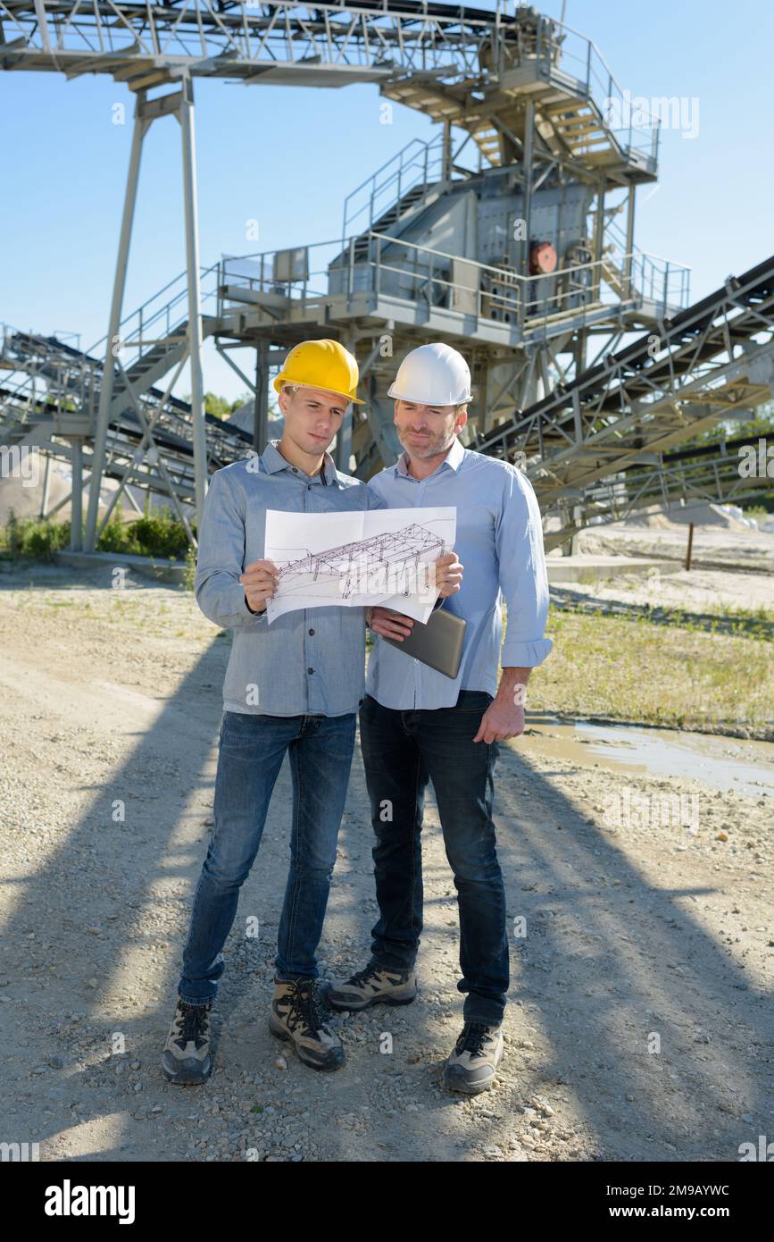 young construction engineer holding blueprint Stock Photo - Alamy