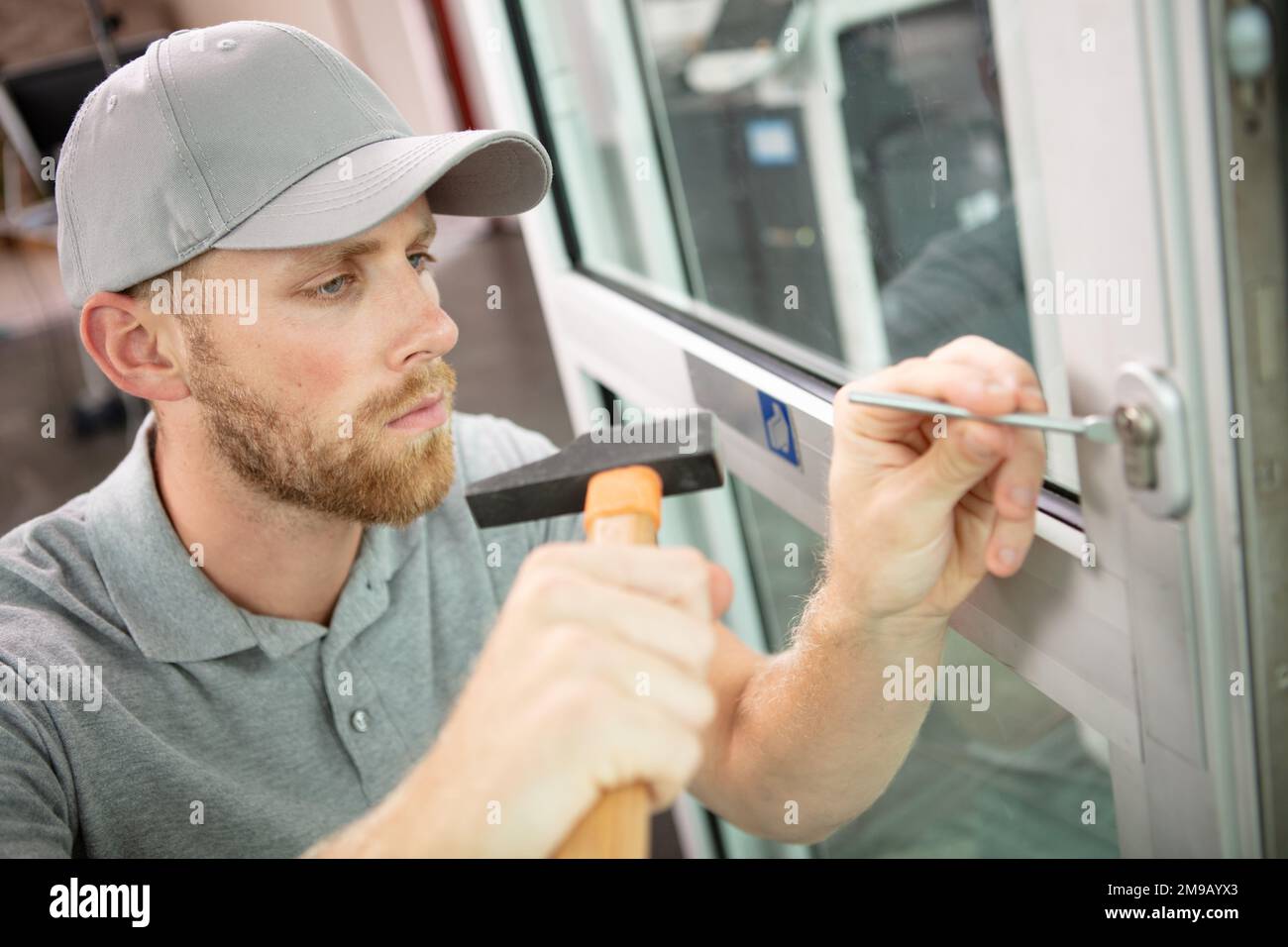 locksmith using hammer to repair lock Stock Photo - Alamy