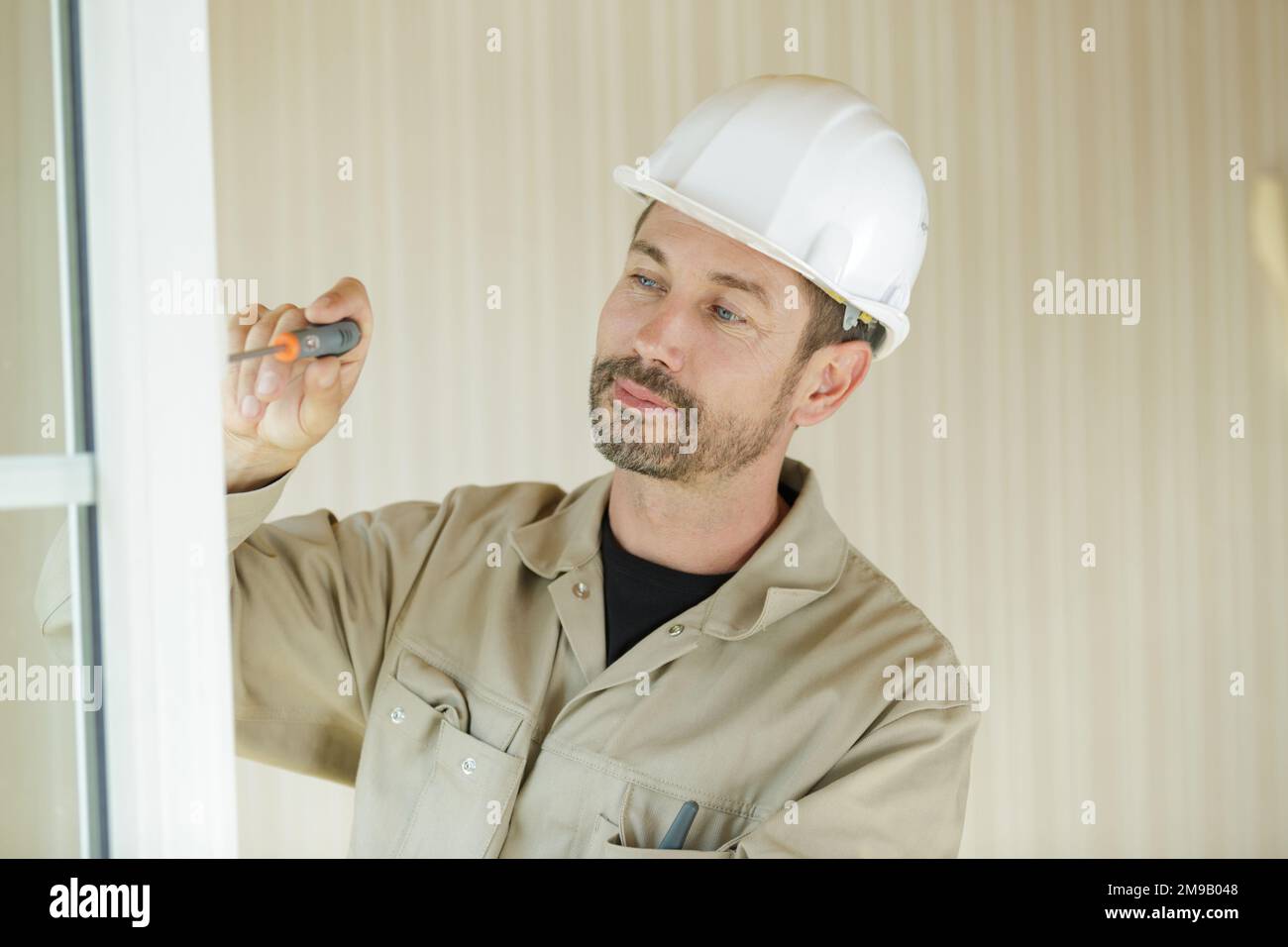 a professional electrician man is fixing the window Stock Photo - Alamy