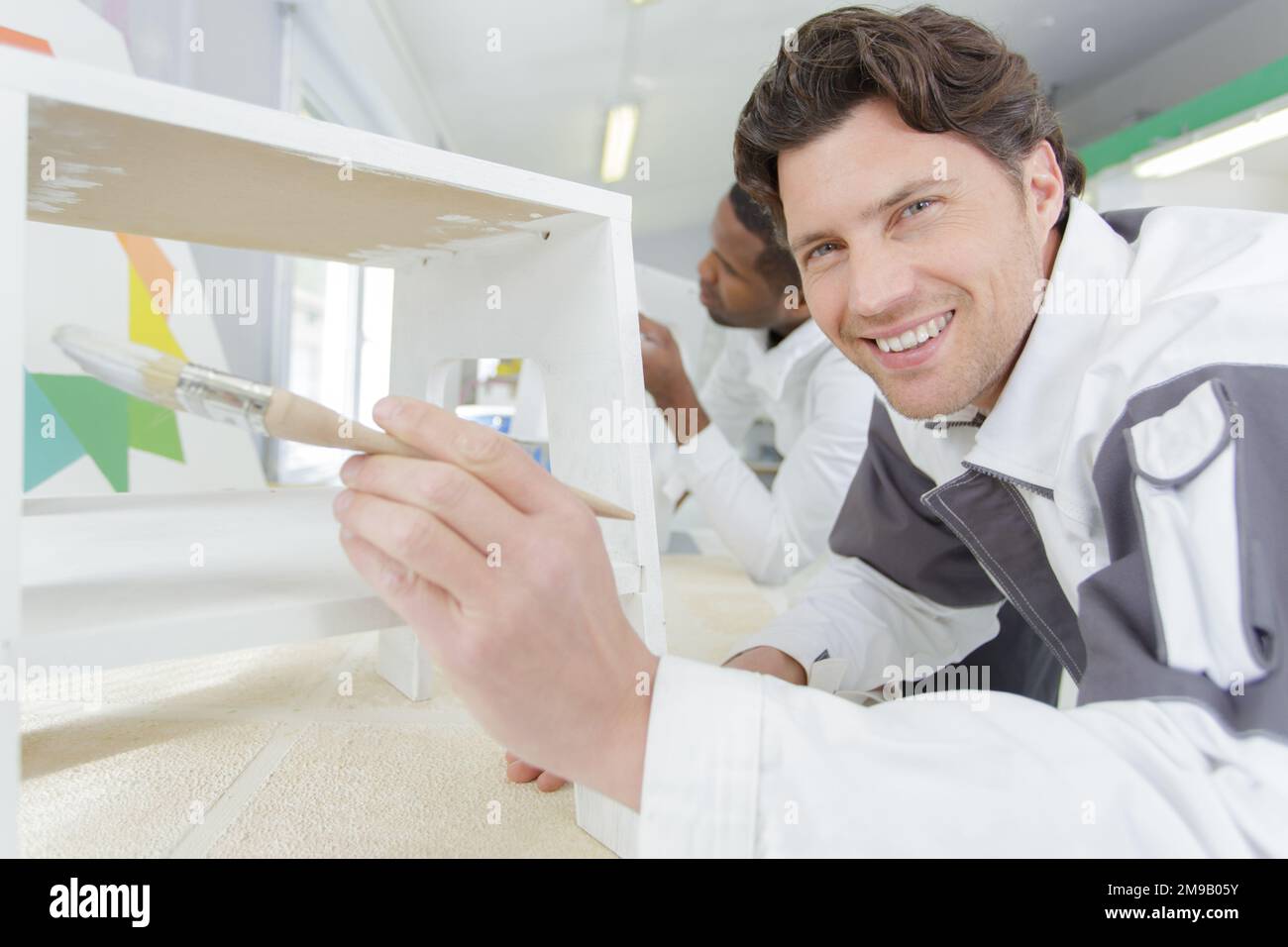 happy male decorator painting a furniture Stock Photo - Alamy