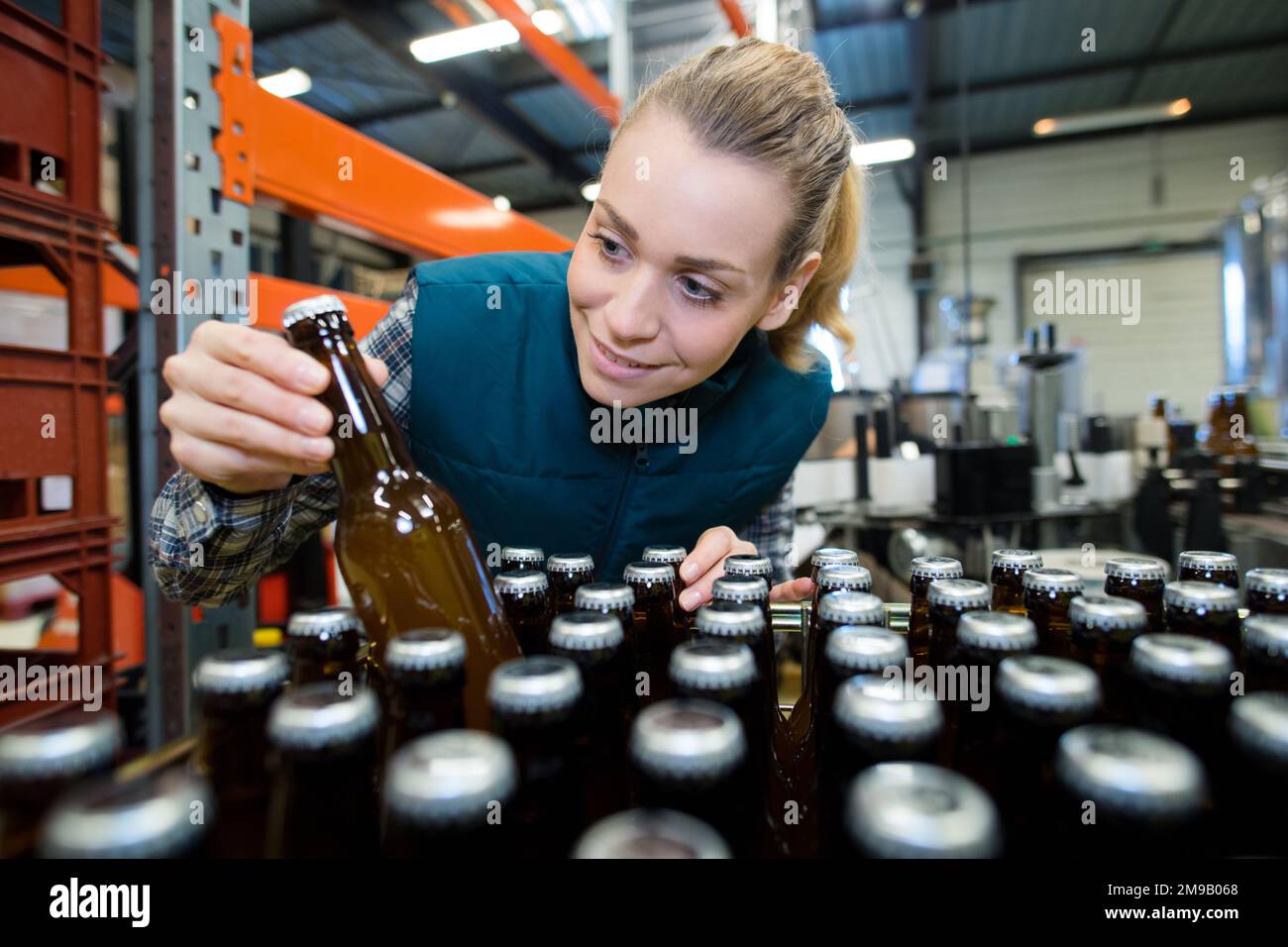 factory worker operating conveyor with beer bottles Stock Photo - Alamy