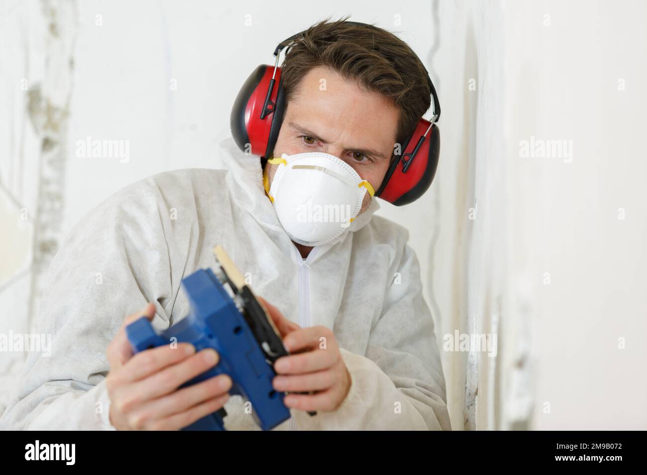 man wearing mask holding electric sander Stock Photo - Alamy
