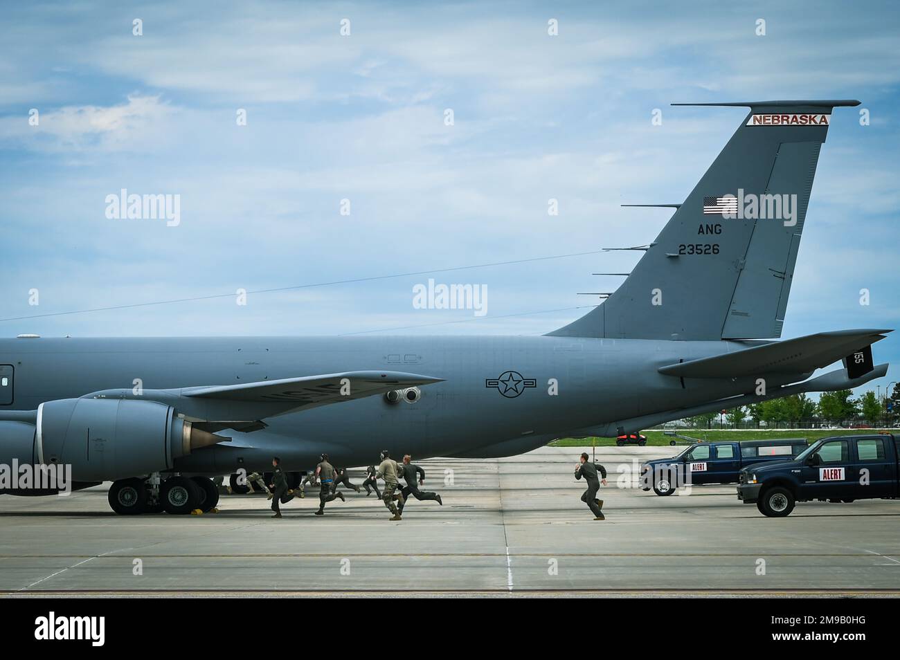 Airmen from the 155th Air Refueling Wing run towards their KC-135R ...