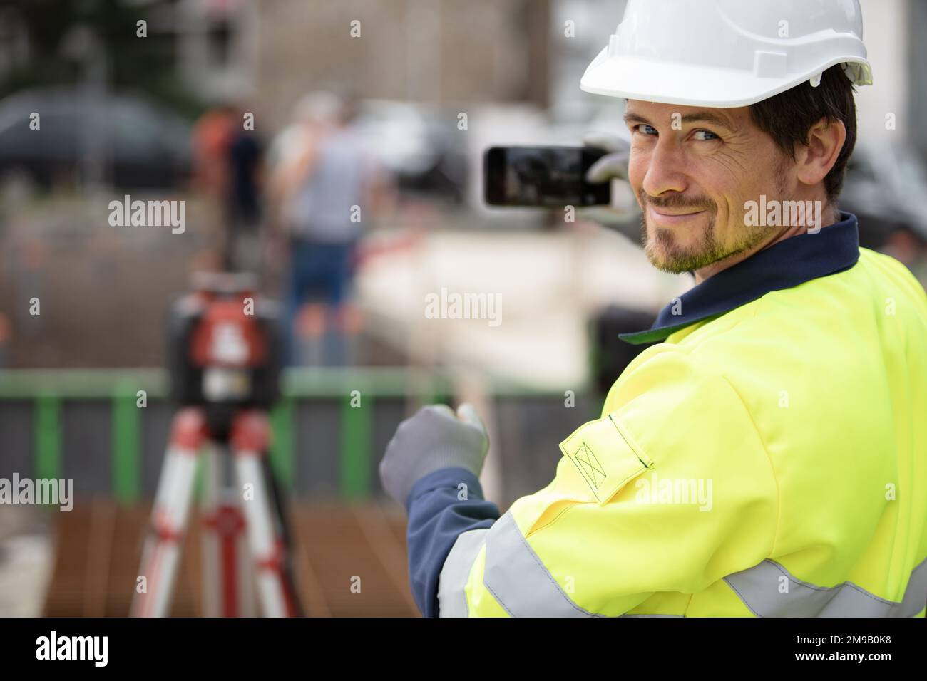 surveyor using smartphone stood by theodolite equipment Stock Photo - Alamy