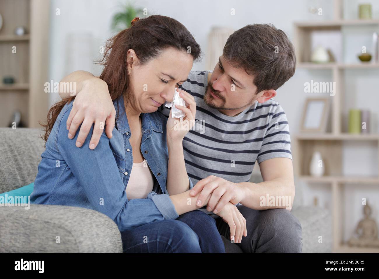 woman is crying while her man is calming her Stock Photo - Alamy