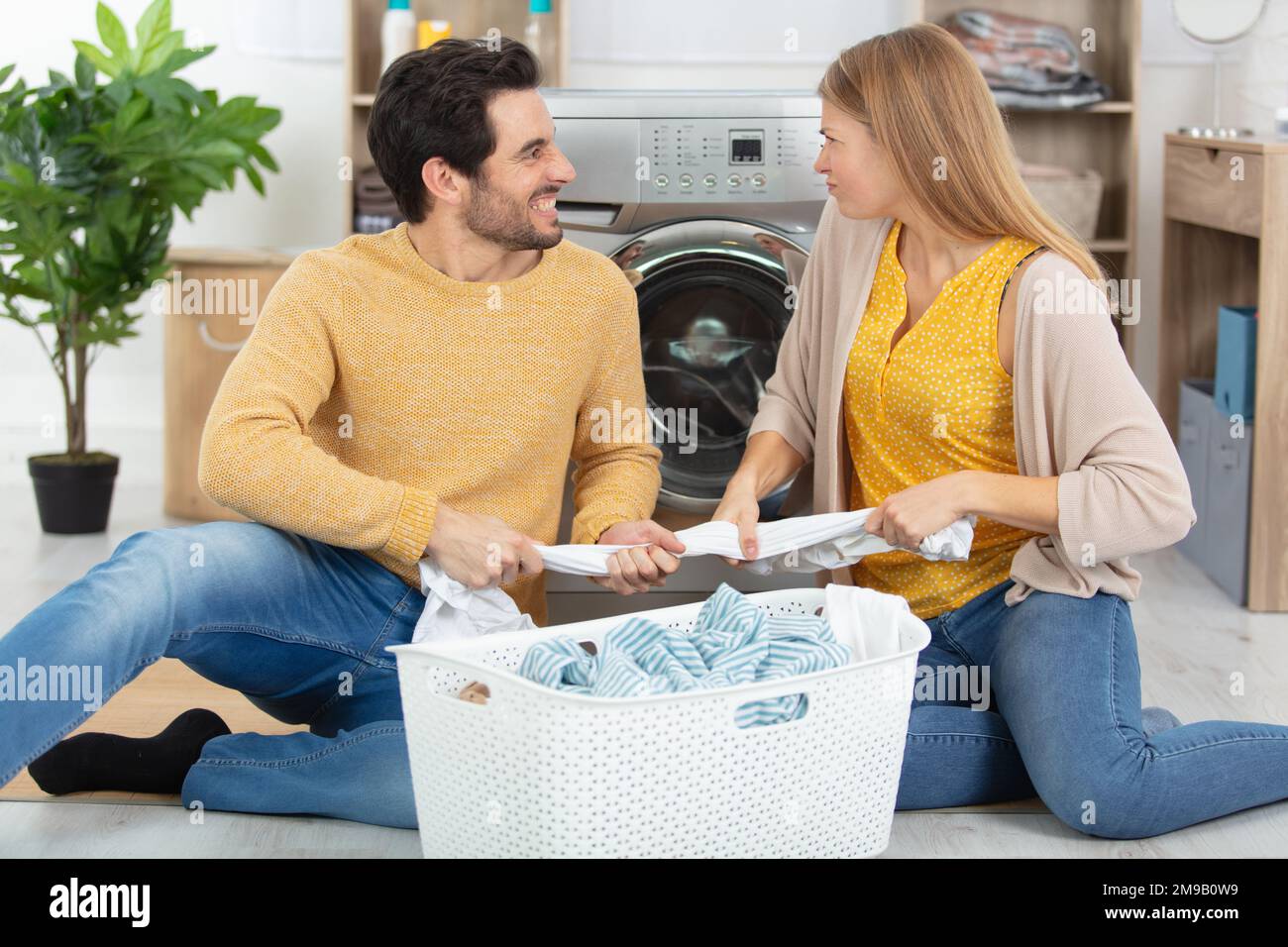 beautiful young loving couple doing laundry at home Stock Photo - Alamy
