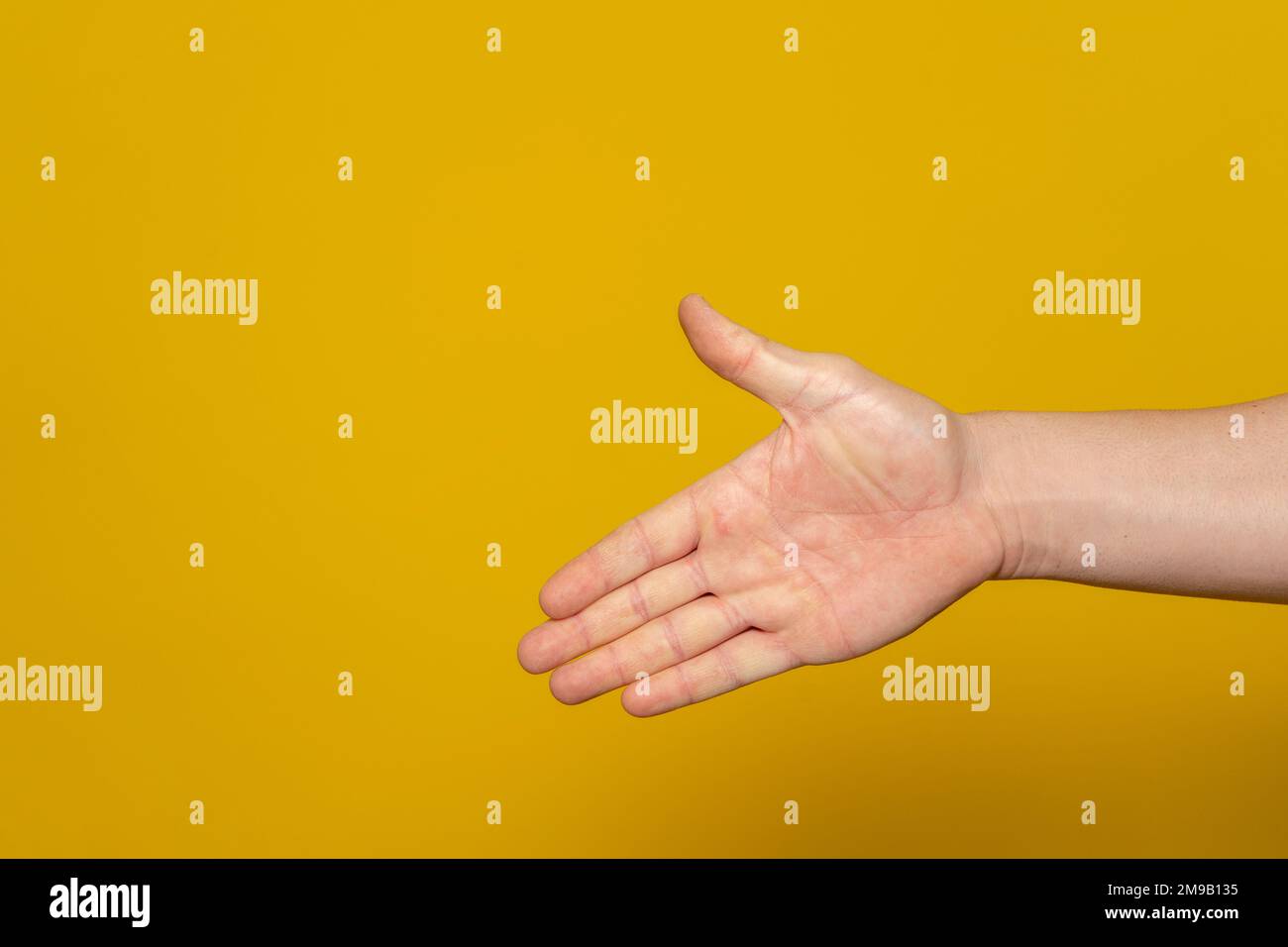 Man stretching out his hand to handshake isolated on an orange ...