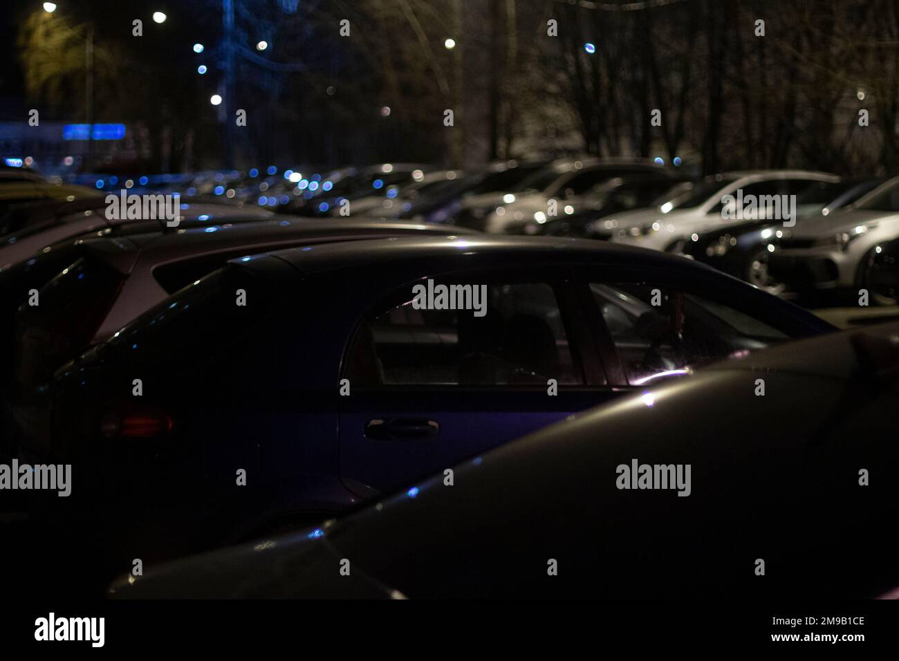 Cars at night in parking lot. Transport in dark. Cars stand in row in ...