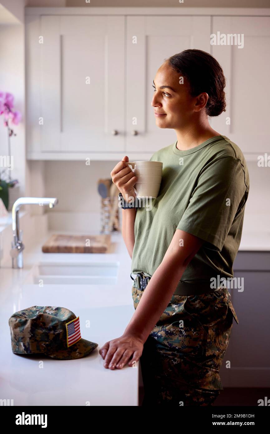 Female American Soldier In Uniform In Kitchen On Home Leave Looking Out ...