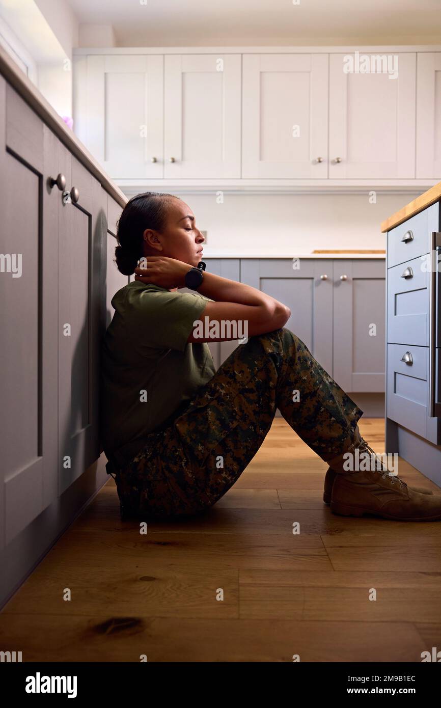 Depressed Female Soldier In Uniform Suffering With PTSD Sitting On ...