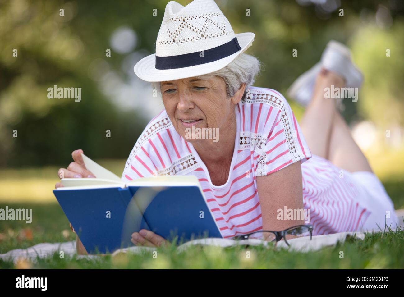 Happy senior woman reading tree hi-res stock photography and images - Alamy