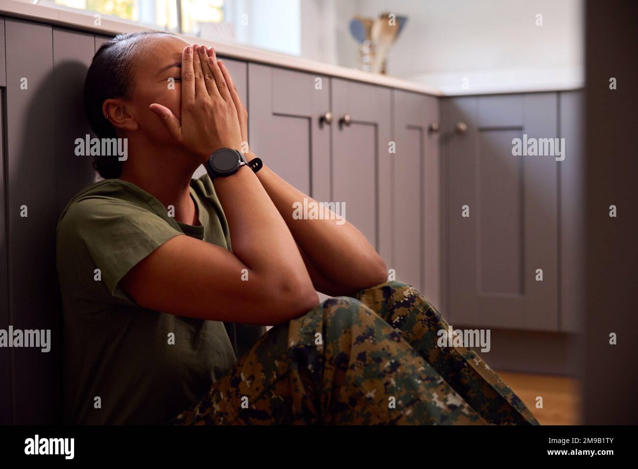 Depressed Female Soldier In Uniform Suffering With PTSD Sitting On ...