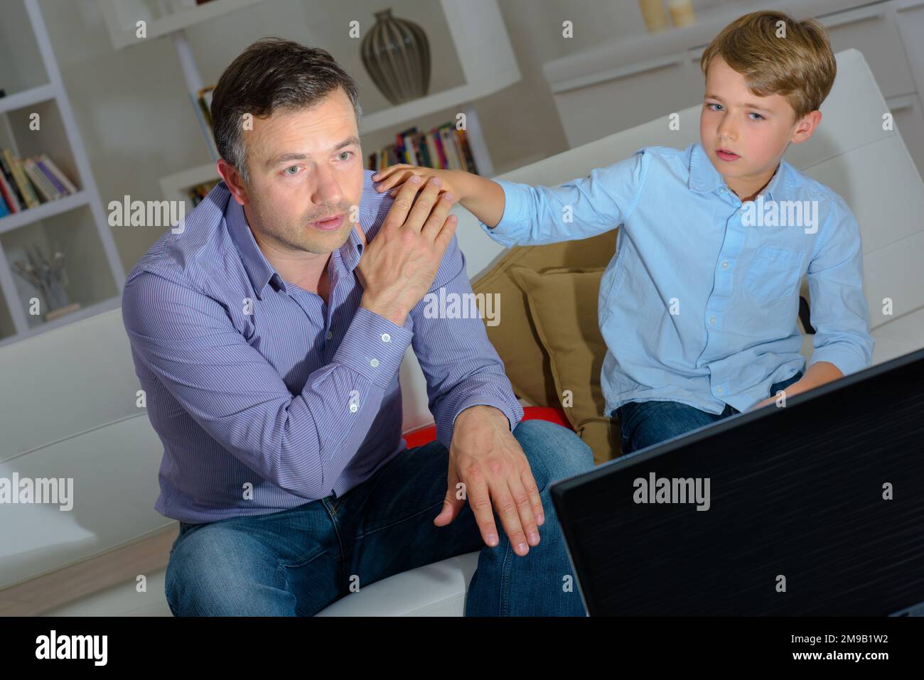 a father and son watching tv Stock Photo - Alamy