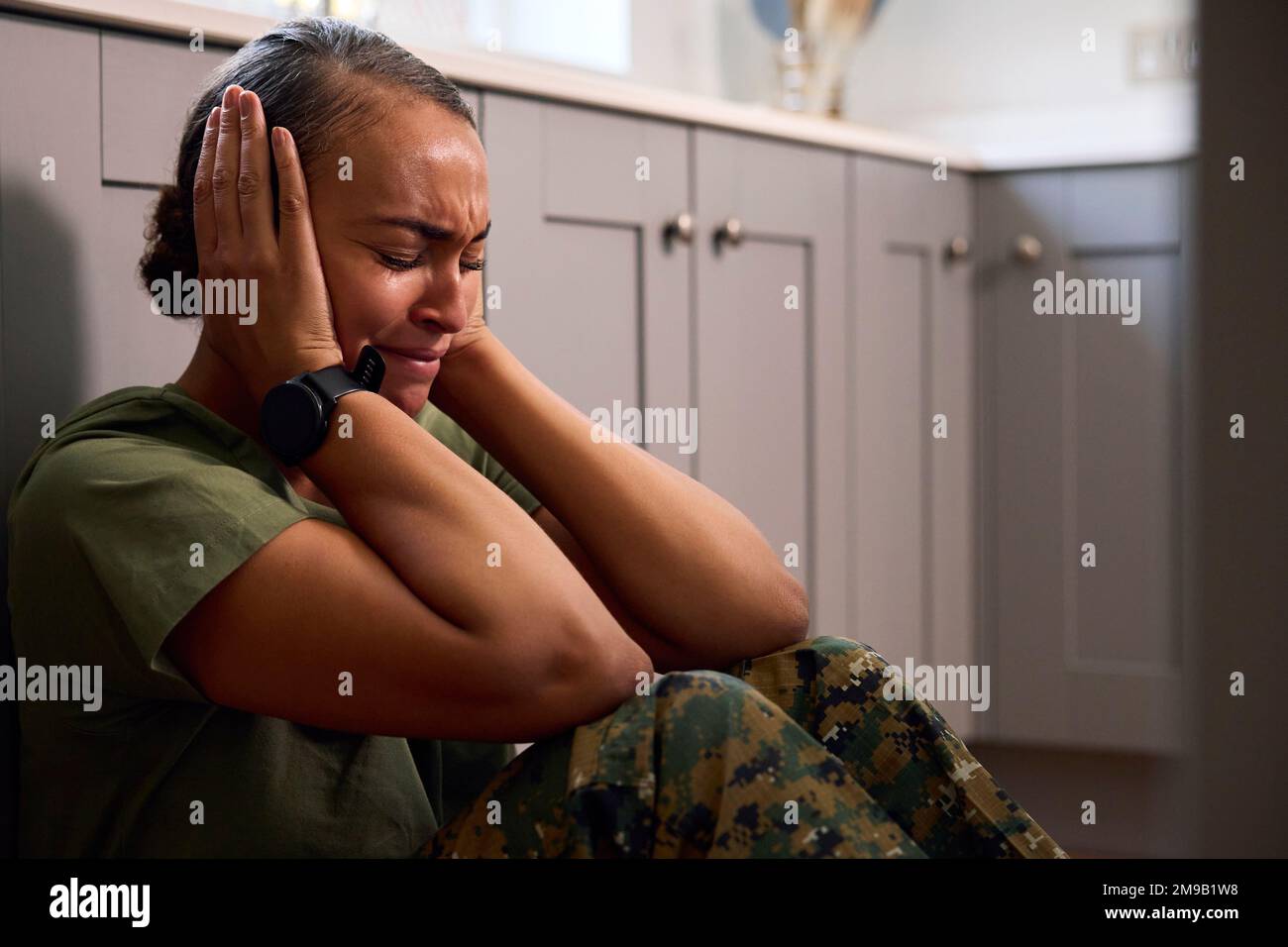 Depressed Female Soldier In Uniform Suffering With PTSD Sitting On ...