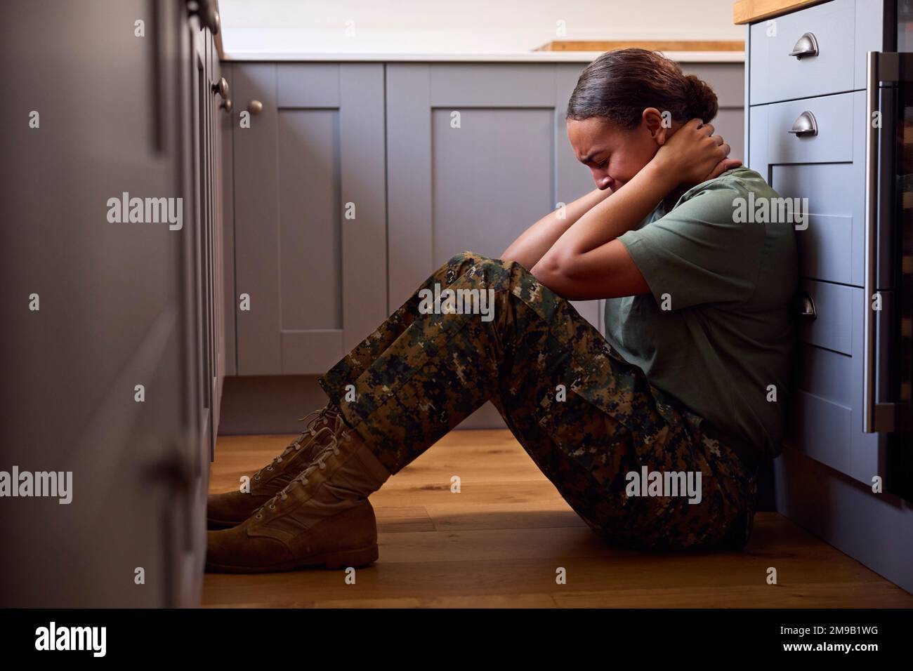 Depressed Female Soldier In Uniform Suffering With PTSD Sitting On ...