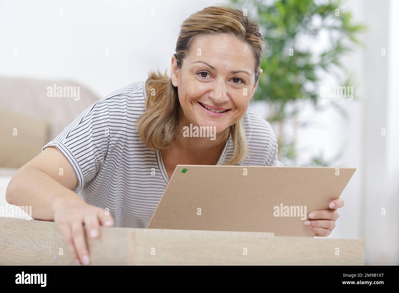 woman putting together self assembly furniture Stock Photo - Alamy