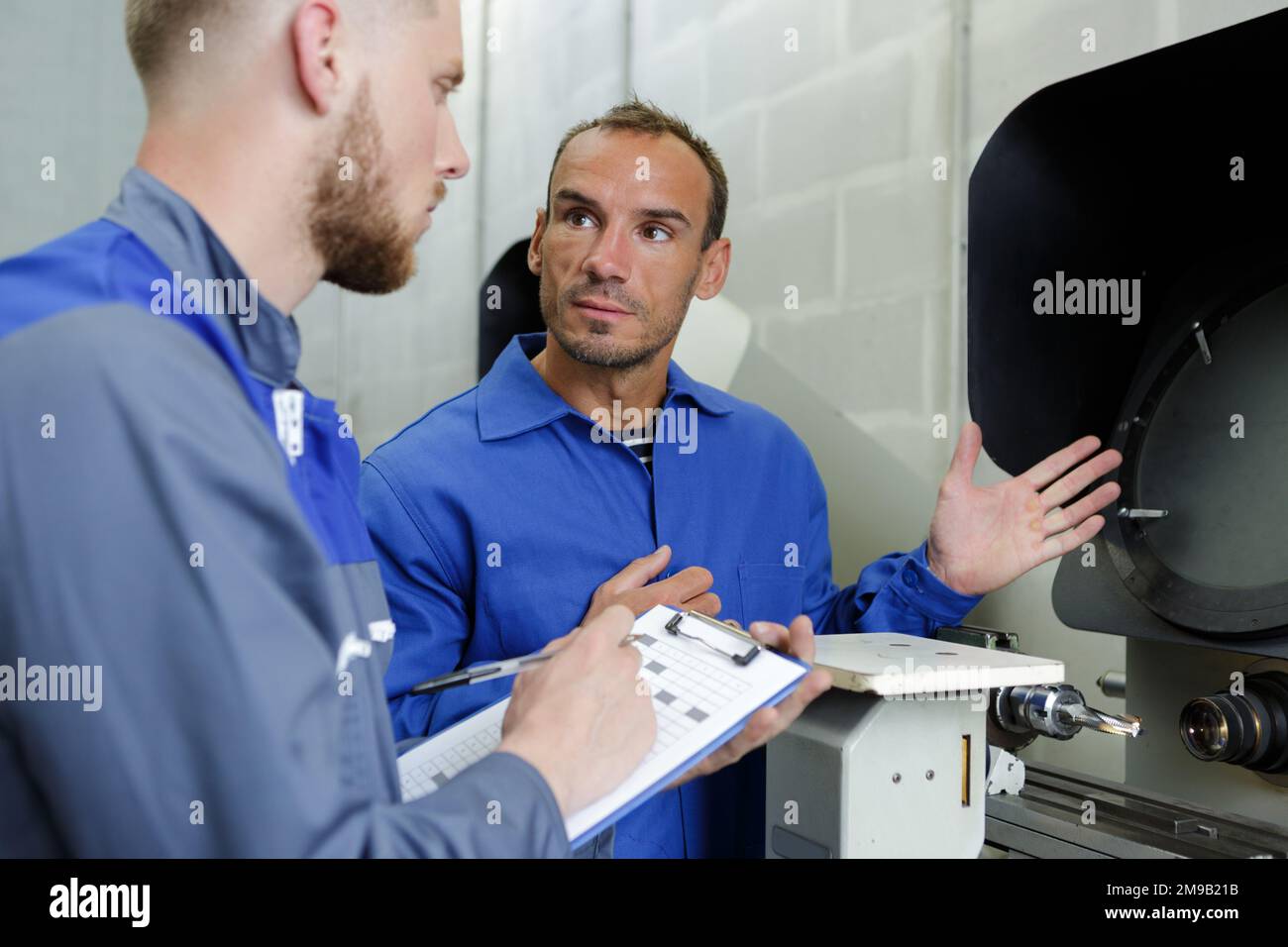 factory apprentice taking notes on clipboard Stock Photo - Alamy